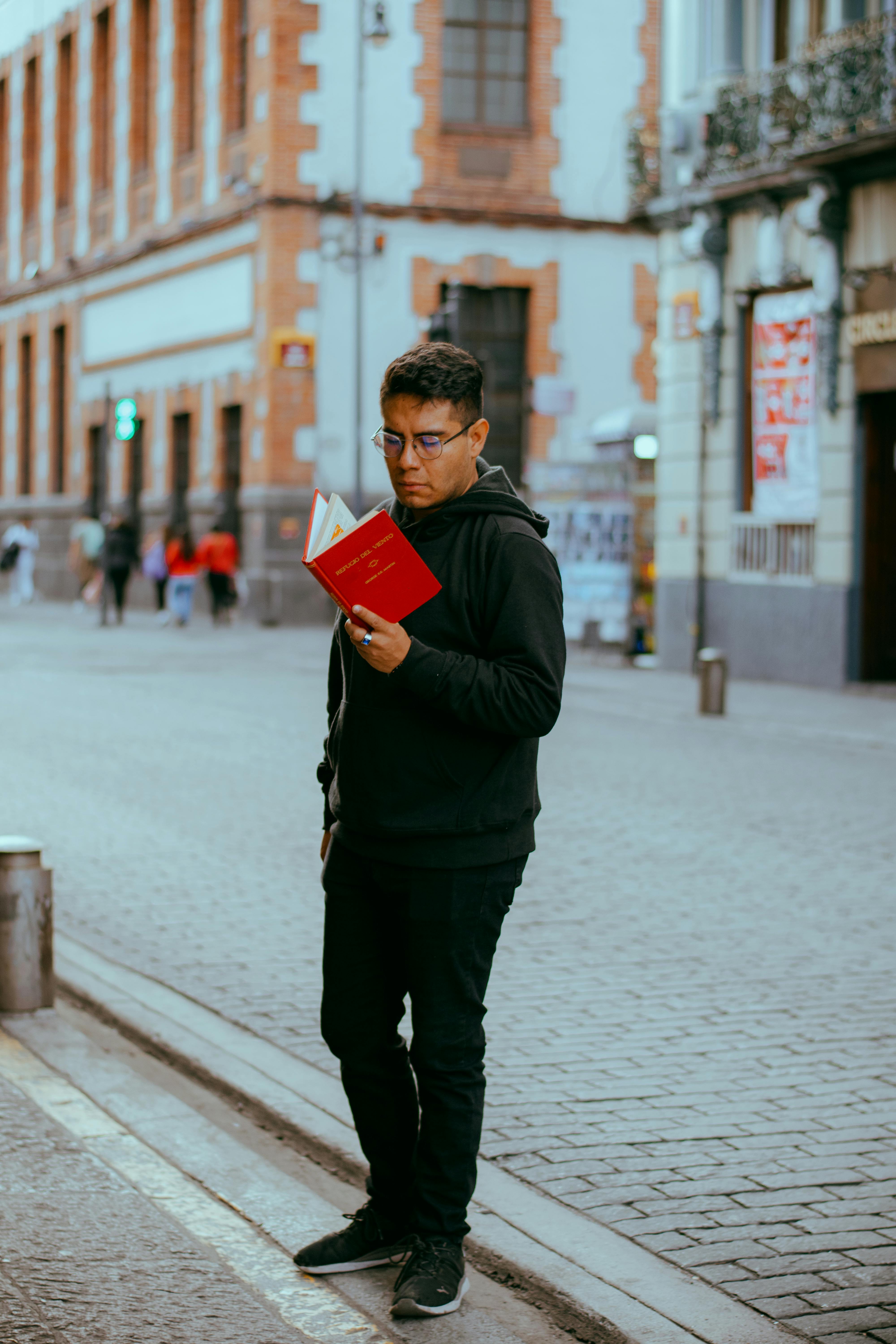Man Reading Book on City Street in Casual Outfit · Free Stock Photo