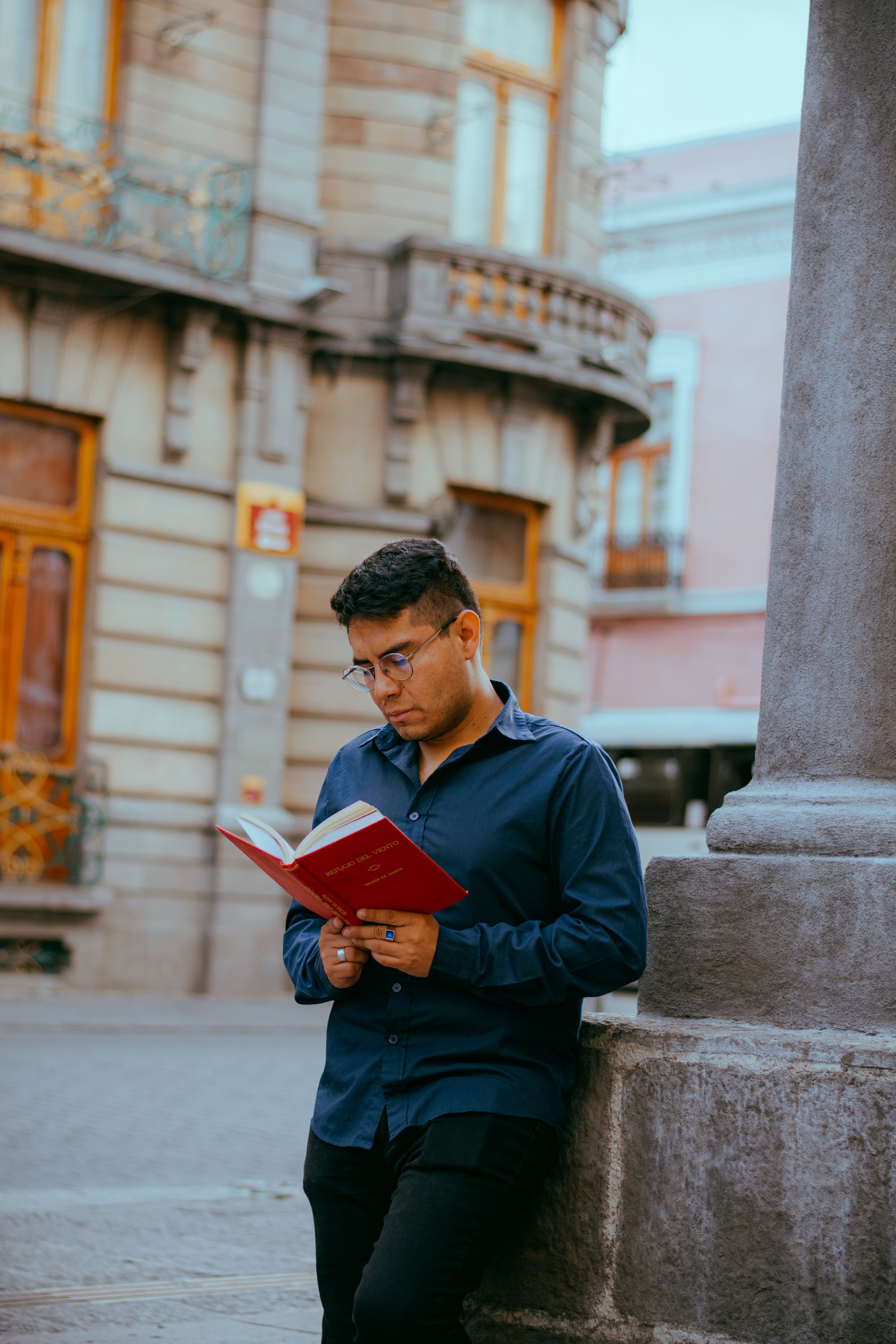 Man Reading Book Outdoors in Urban Setting · Free Stock Photo