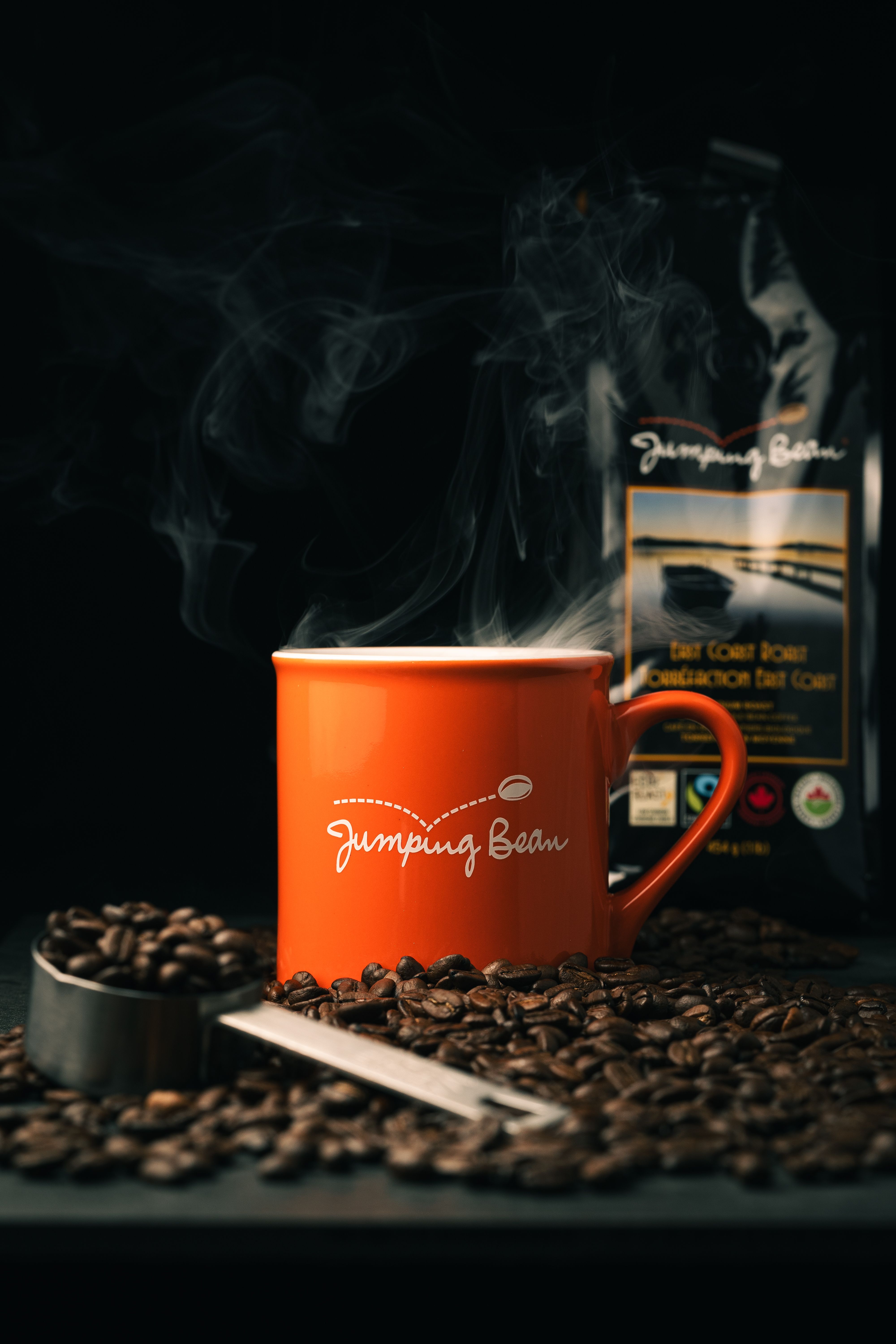 Steaming Coffee Mug with Jumping Bean Logo · Free Stock Photo