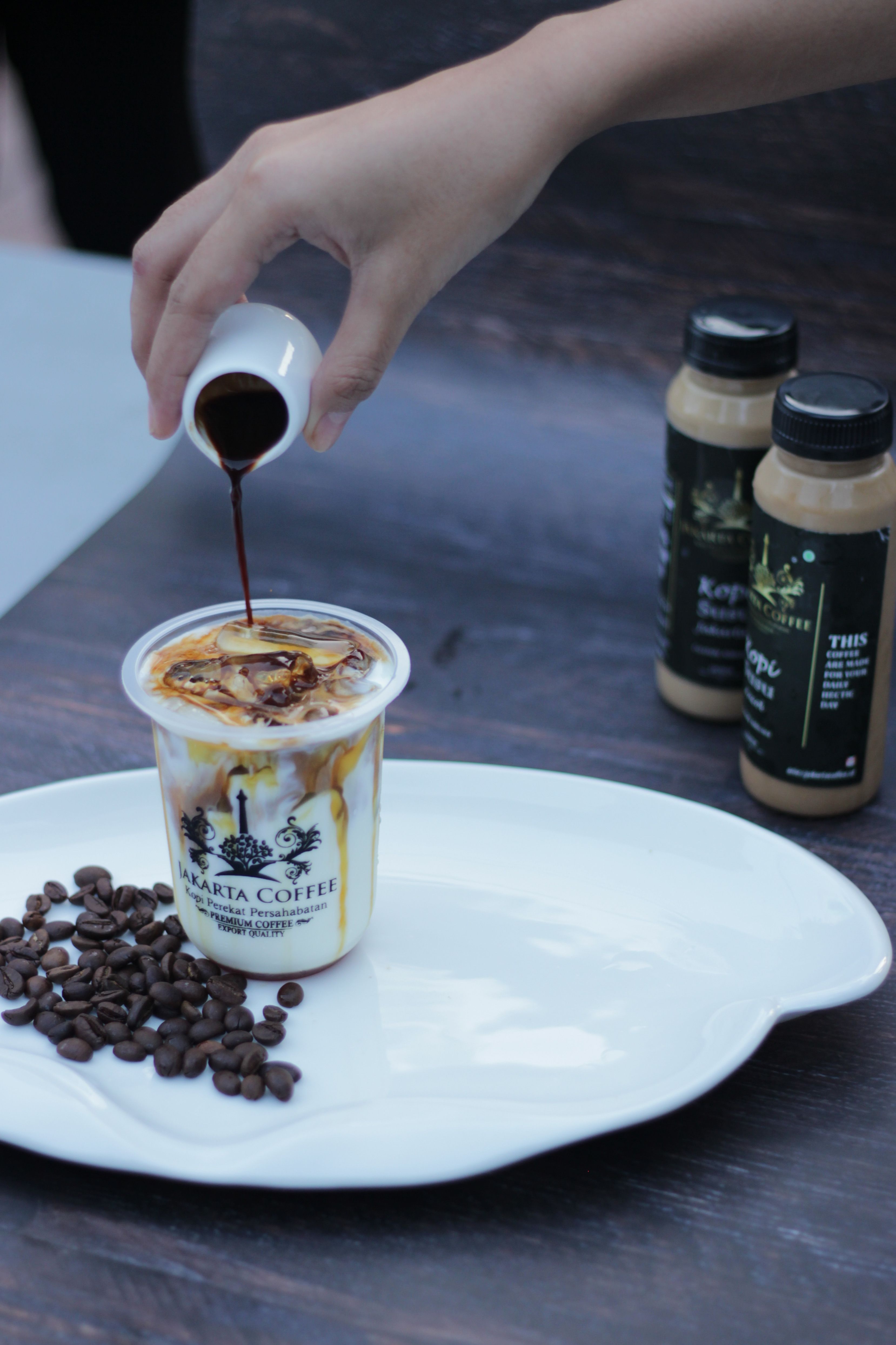 Hand Pouring Syrup into Jakarta Coffee Cup · Free Stock Photo