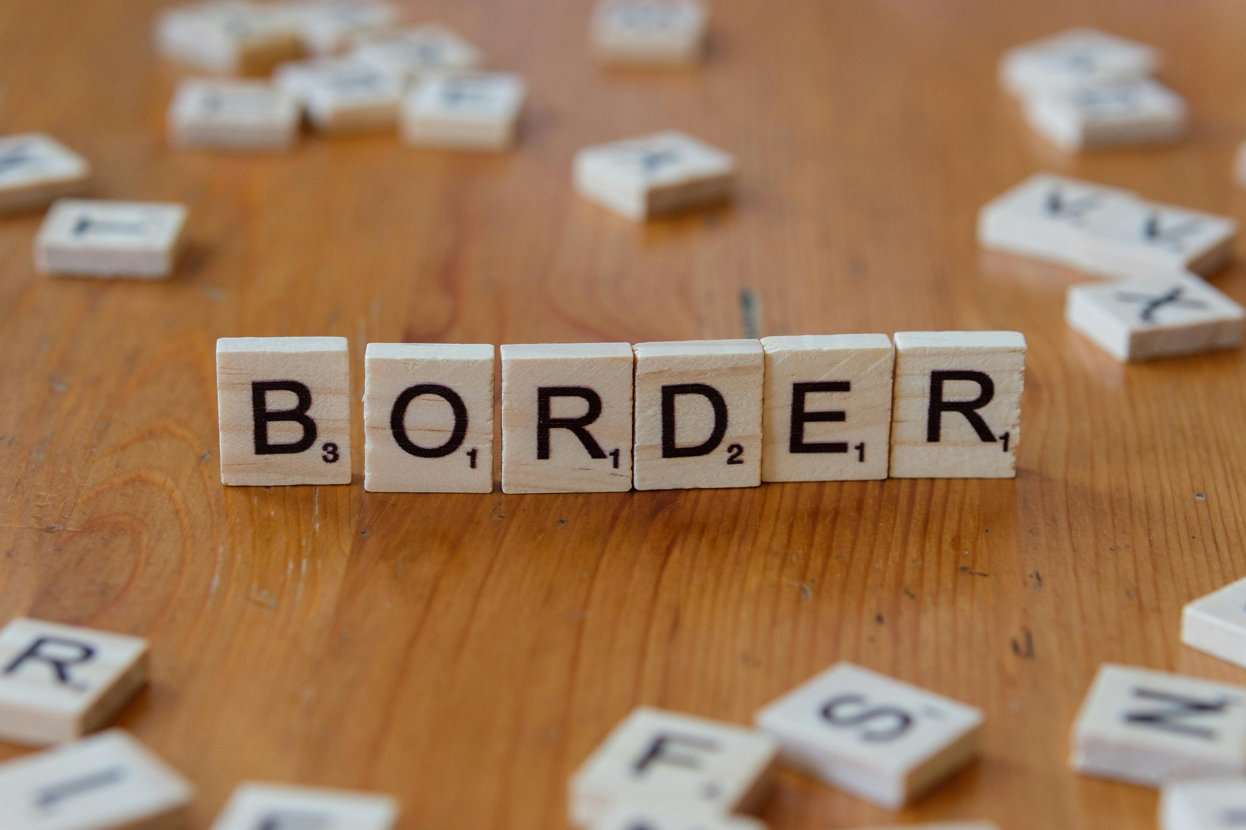 Scrabble Tiles Spelling 'Border' on Wooden Surface · Free Stock Photo