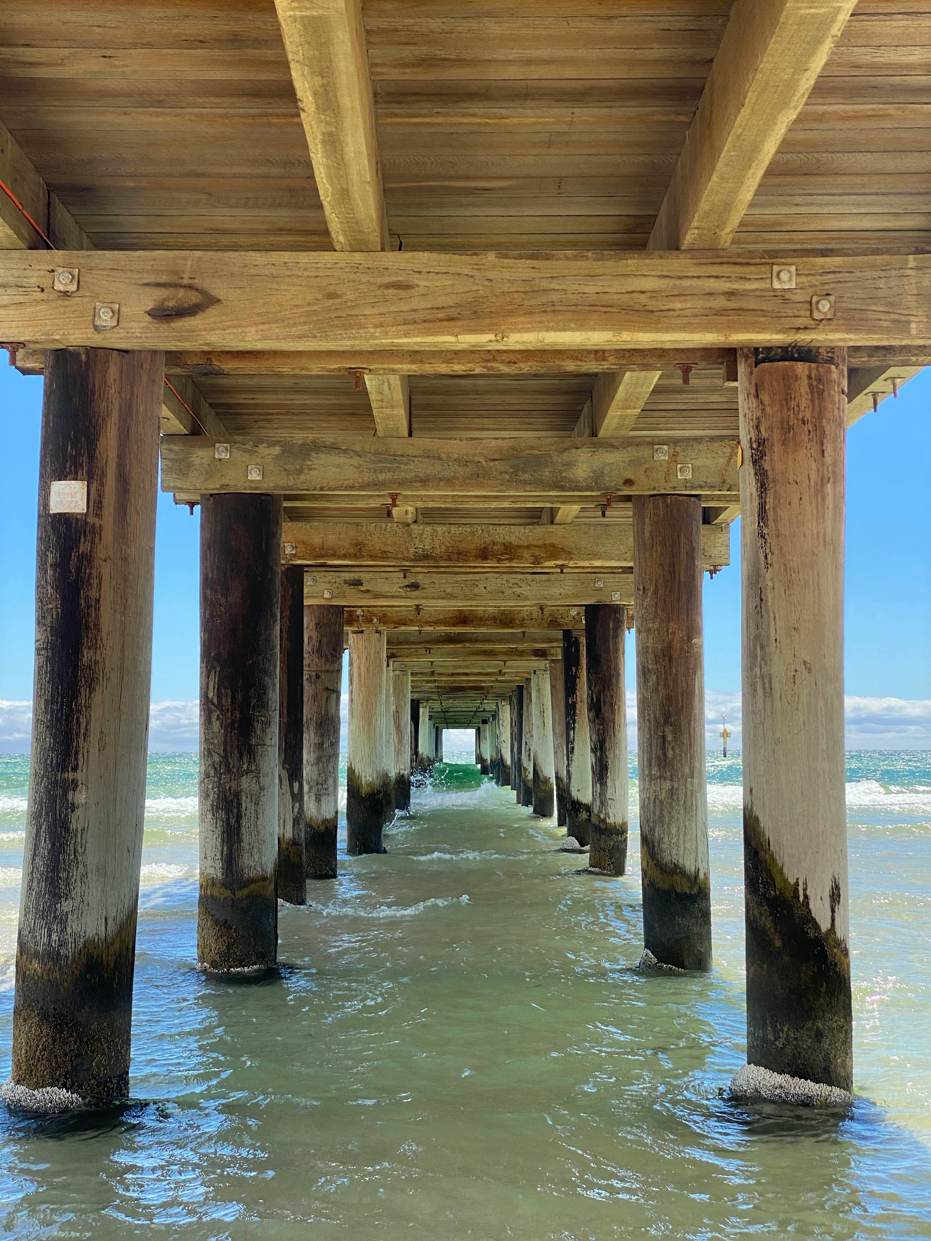 Underneath Wooden Pier with Ocean Waves · Free Stock Photo