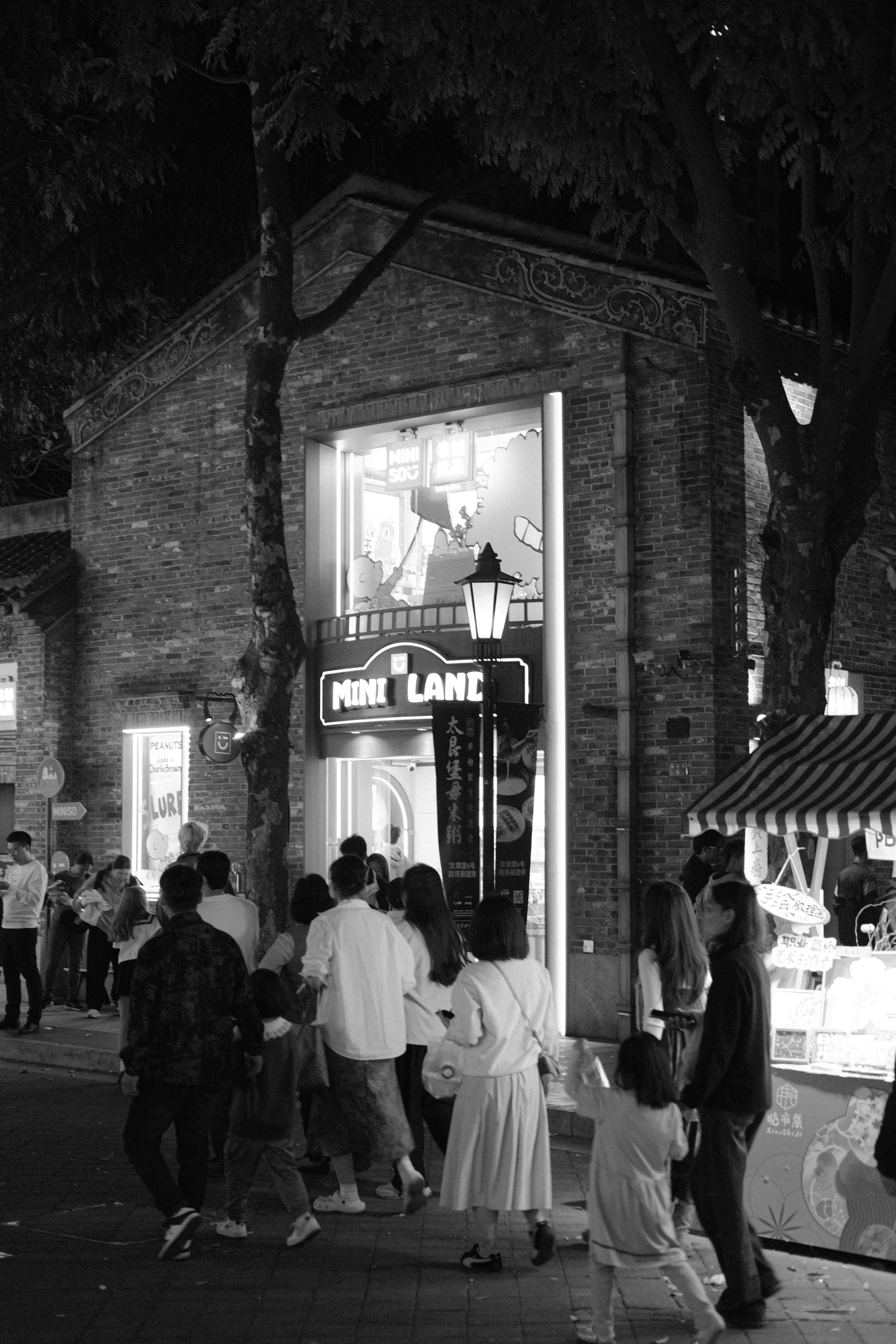 Nighttime Street Crowd Near Brick Building · Free Stock Photo