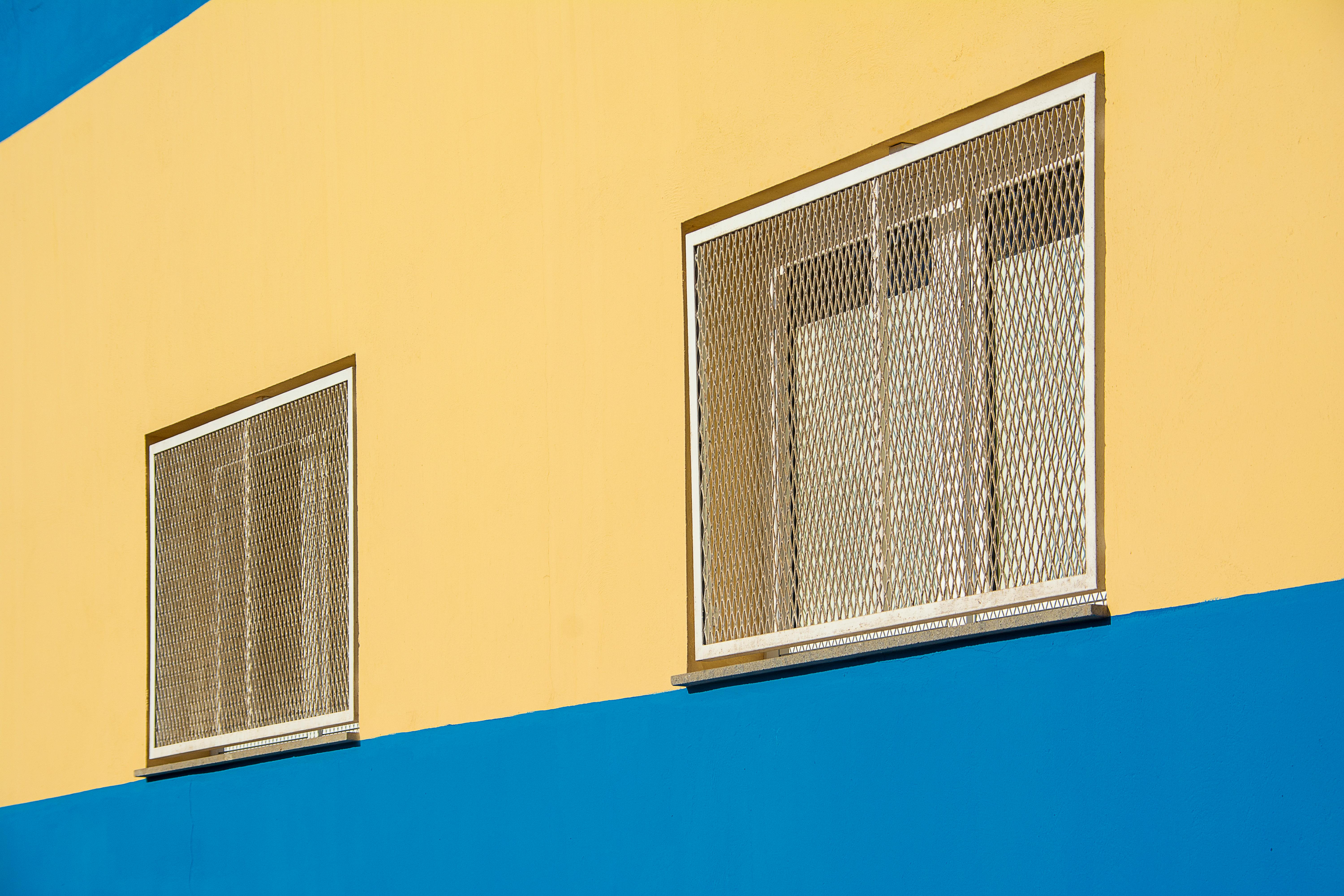 Colorful Building Facade with Wire Mesh Windows · Free Stock Photo