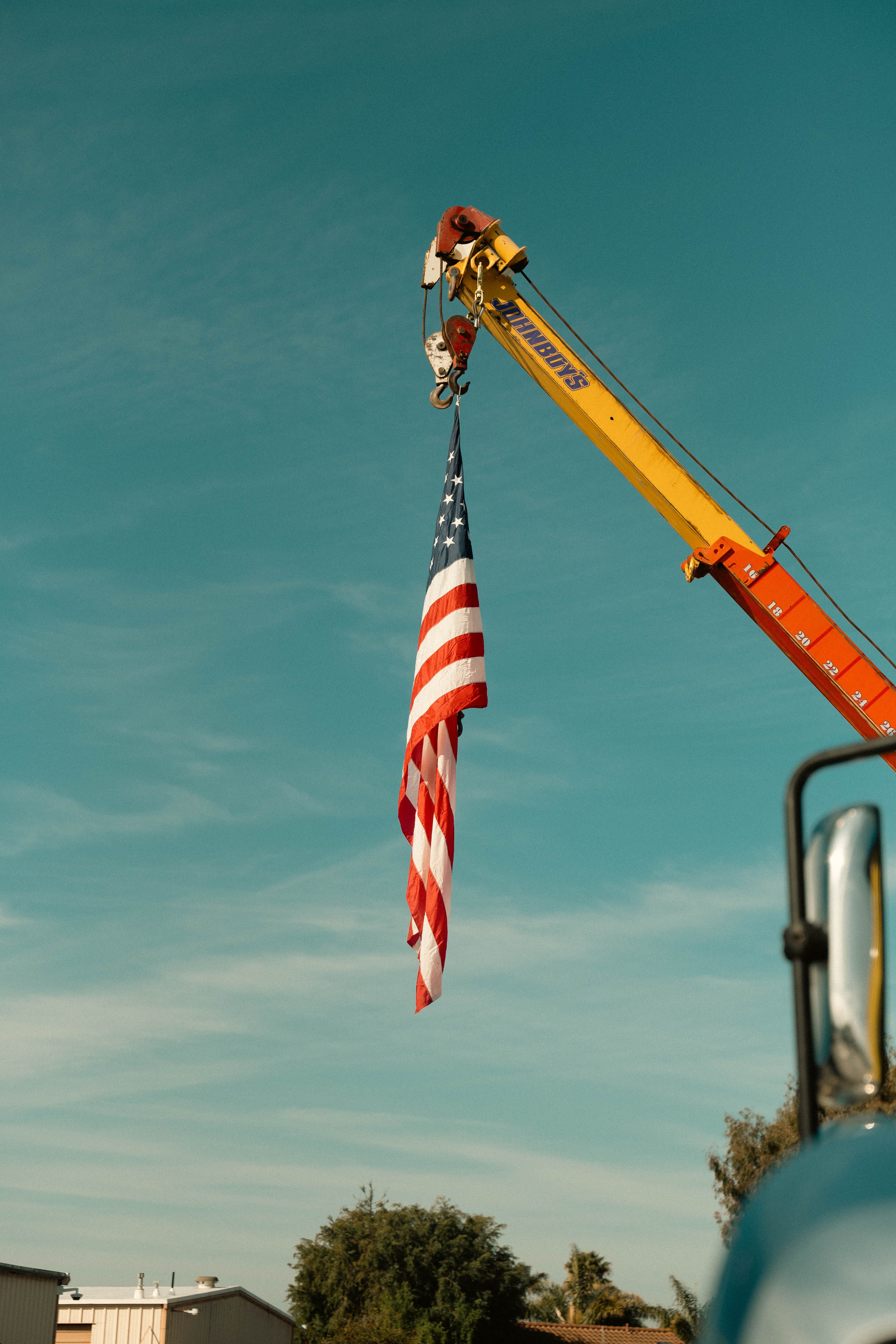 American Flag Hoisted by Construction Crane · Free Stock Photo