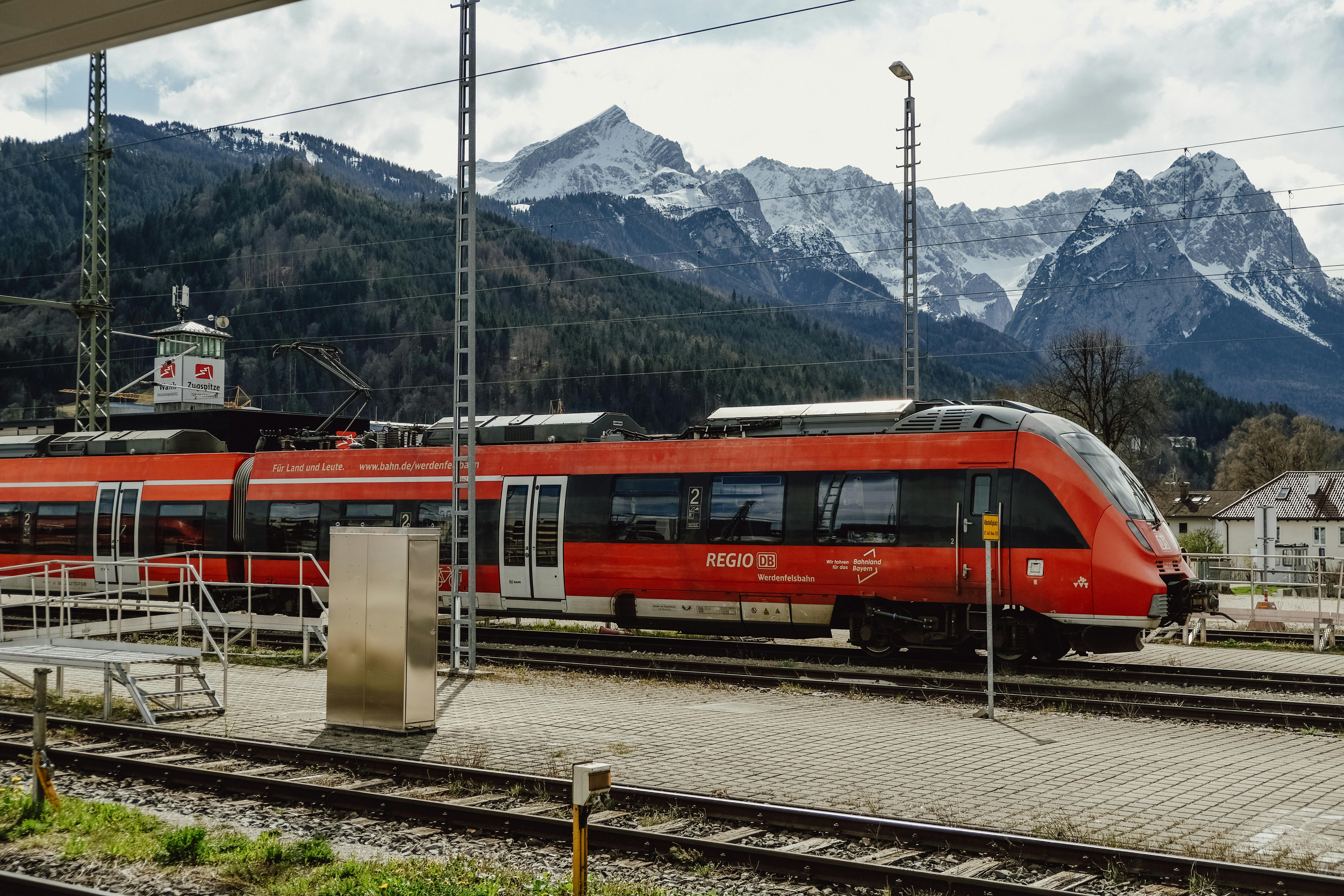 Modern red train at picturesque mountain station · Free Stock Photo