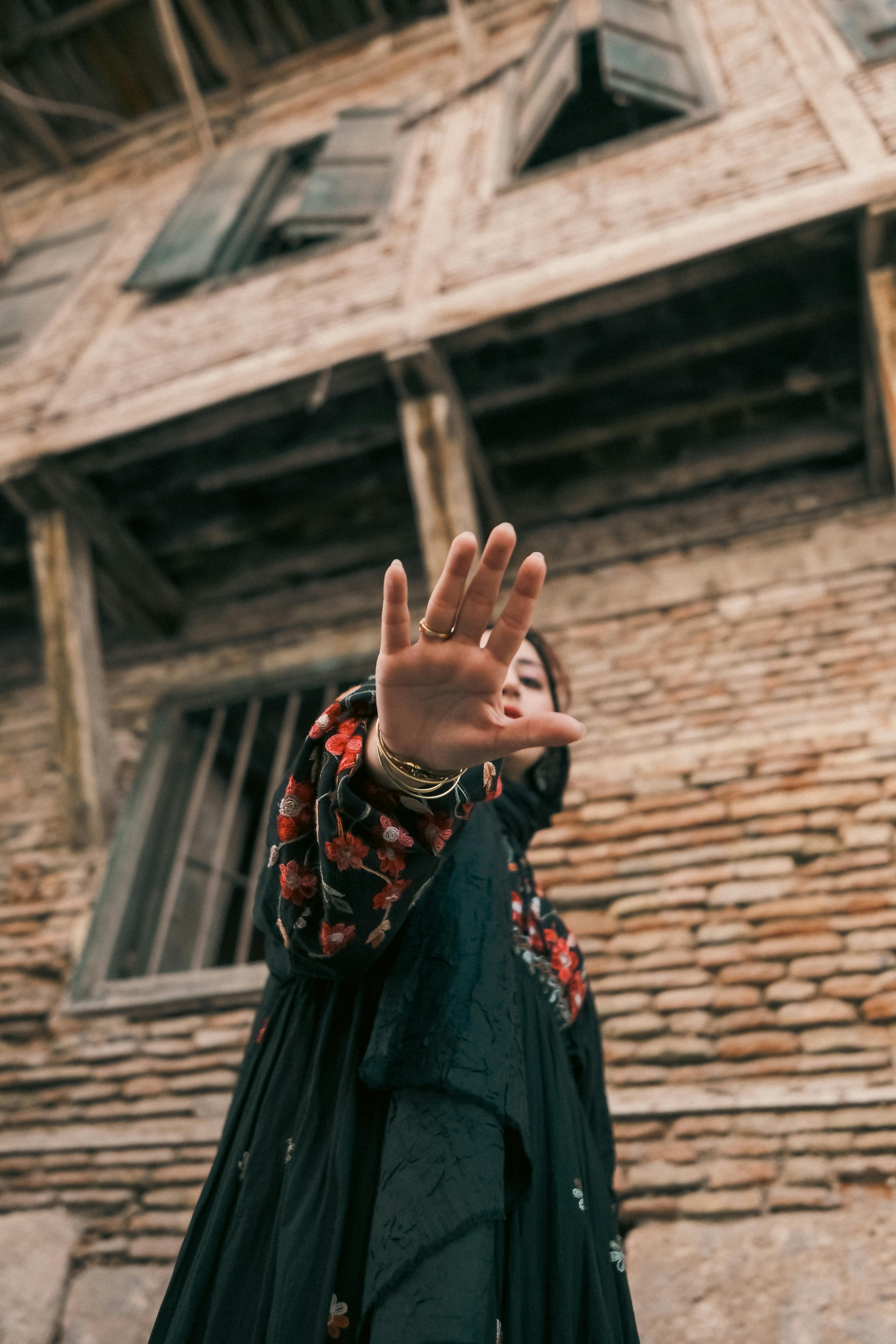 Woman in Traditional Dress Blocking Camera View · Free Stock Photo