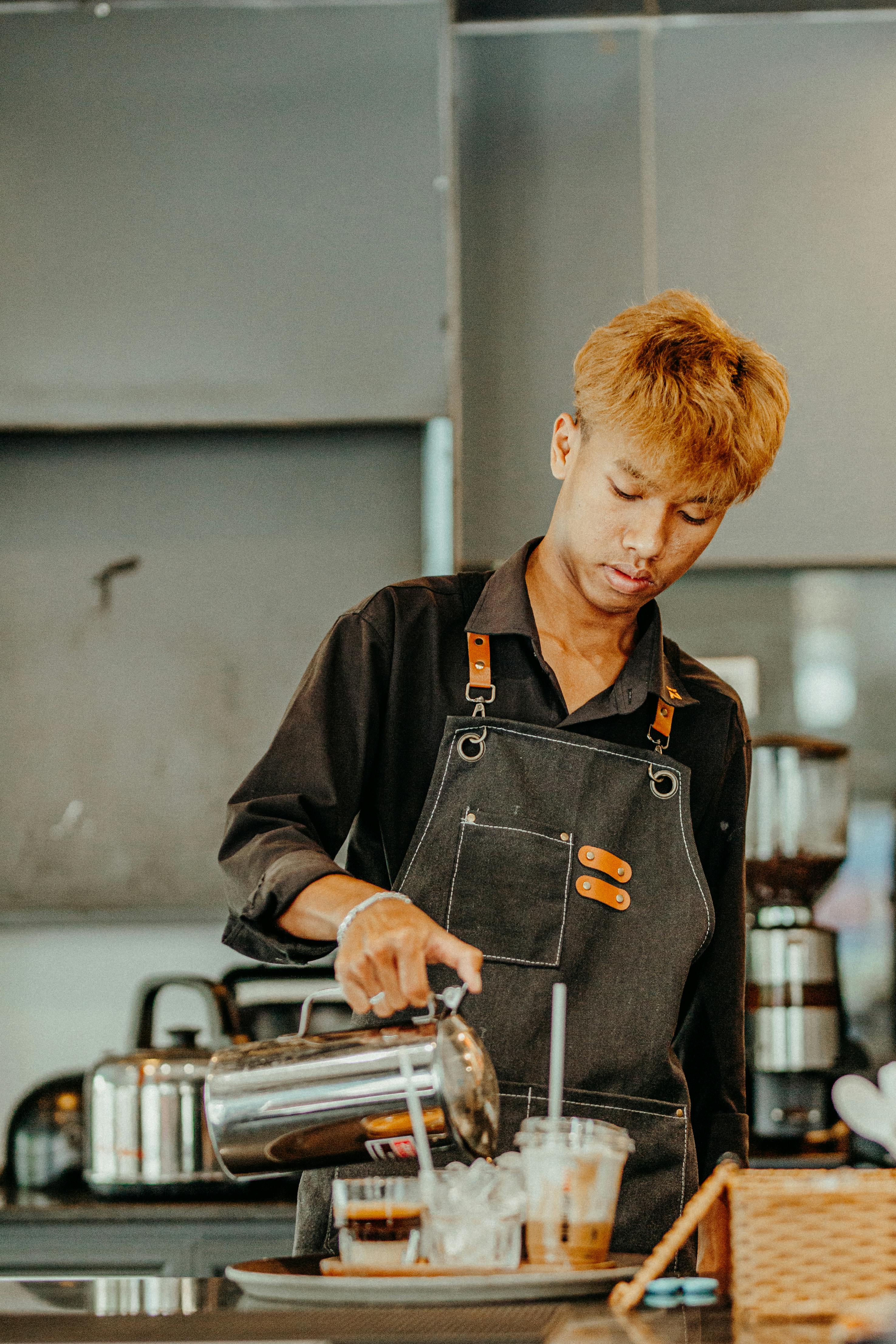 Barista Pouring Coffee in Modern Cafe Setting · Free Stock Photo