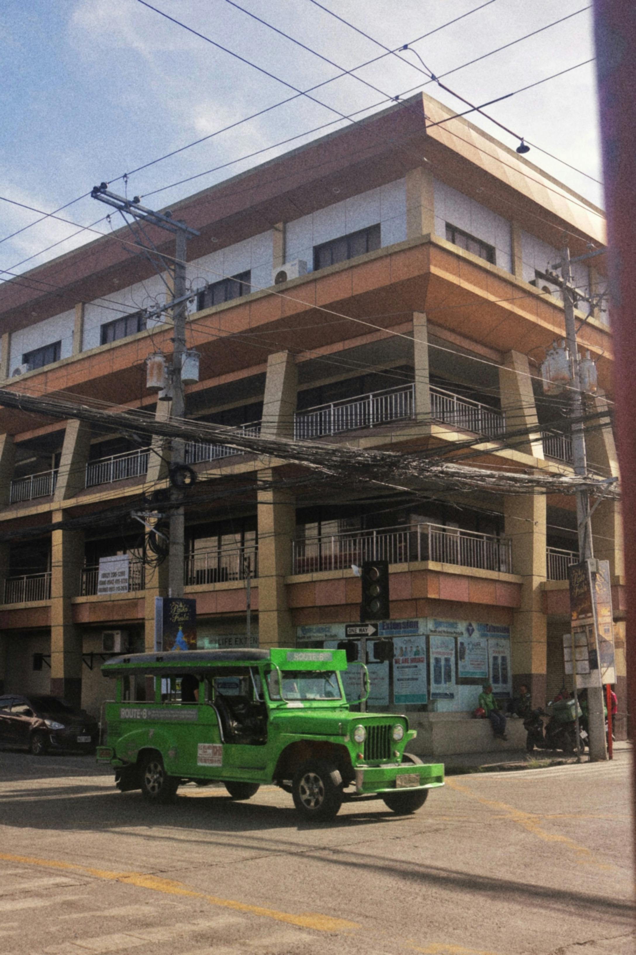 Iconic Jeepney Driving Through Philippine Streets · Free Stock Photo