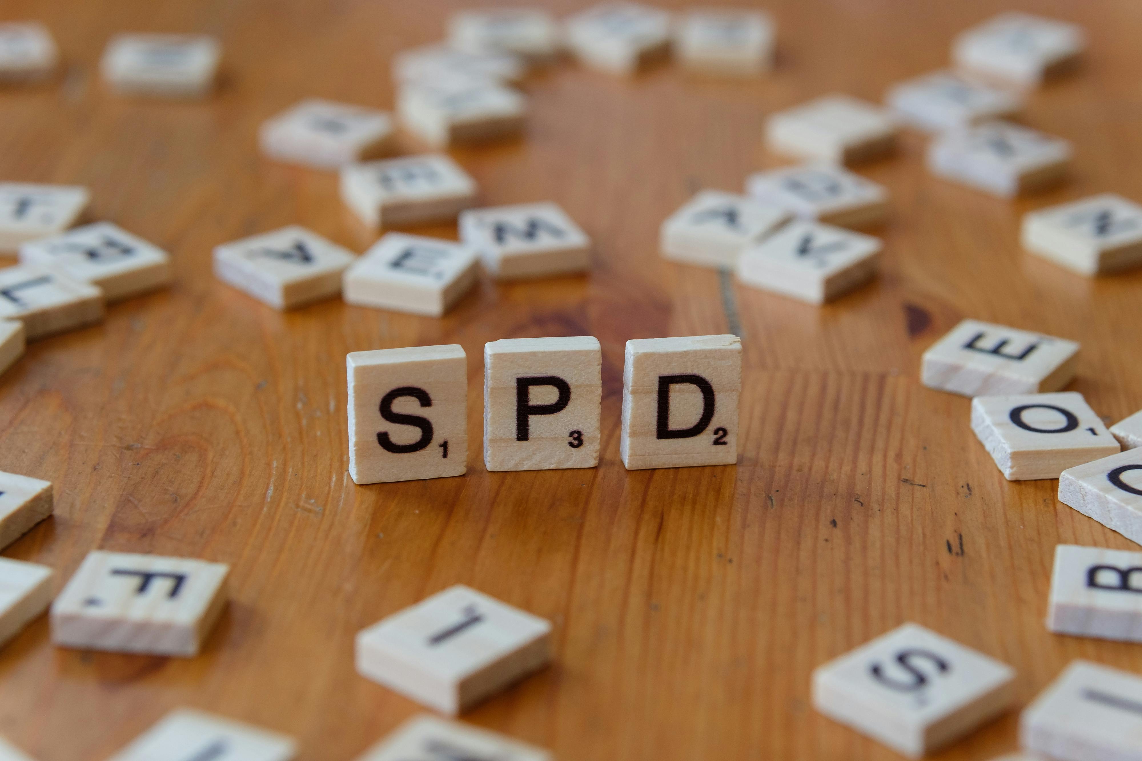 SPD Letters on Scrabble Tiles on Wooden Surface · Free Stock Photo