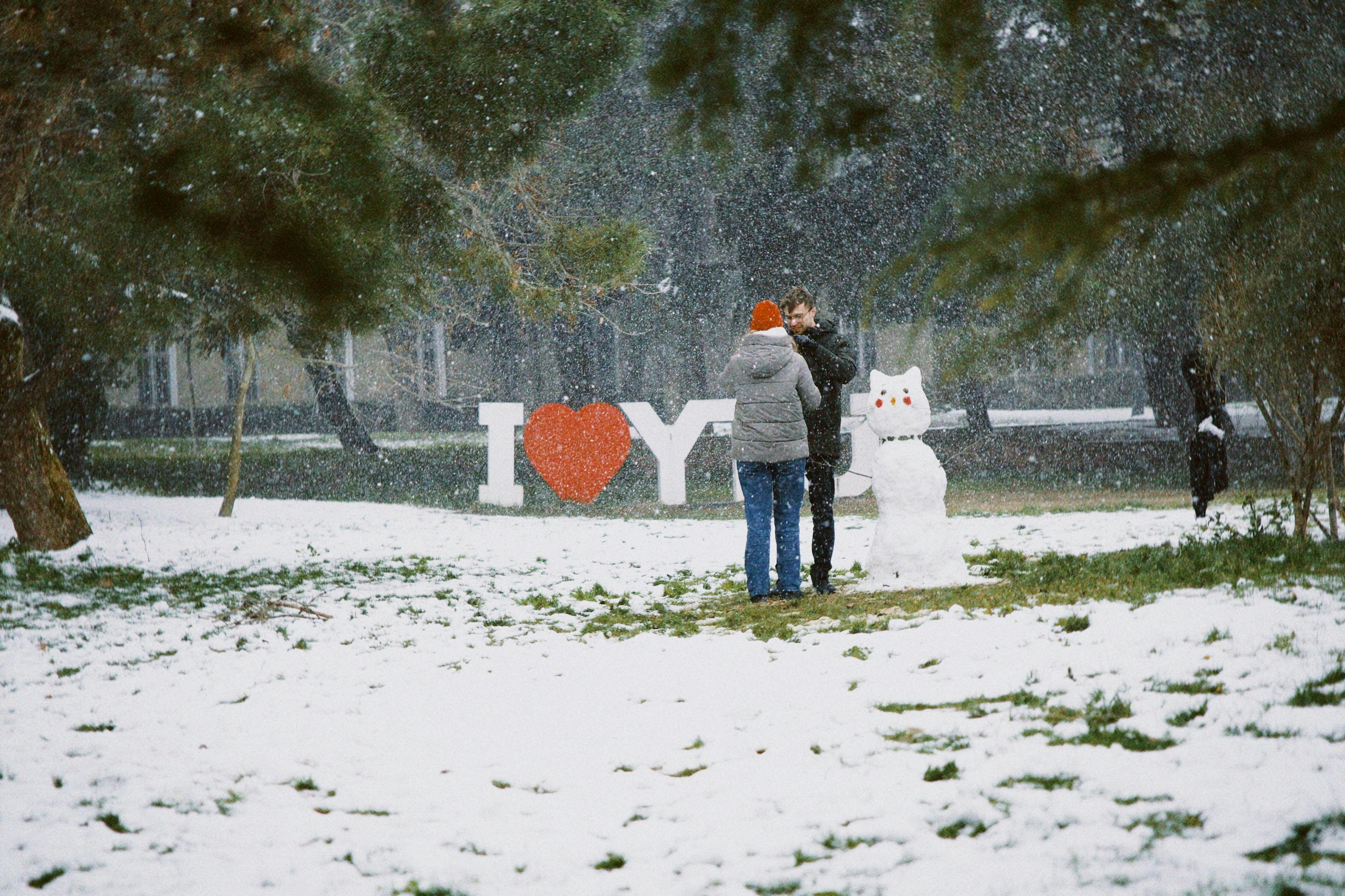 Couple Building Snowman in Winter Wonderland · Free Stock Photo