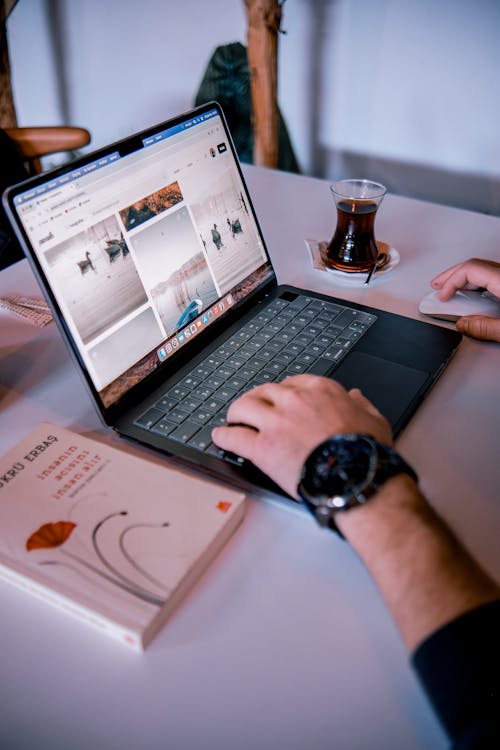 Person Browsing Laptop in Cafeteria Setting · Free Stock Photo Person Browsing Laptop in Cafeteria Setting · Free Stock Photo
