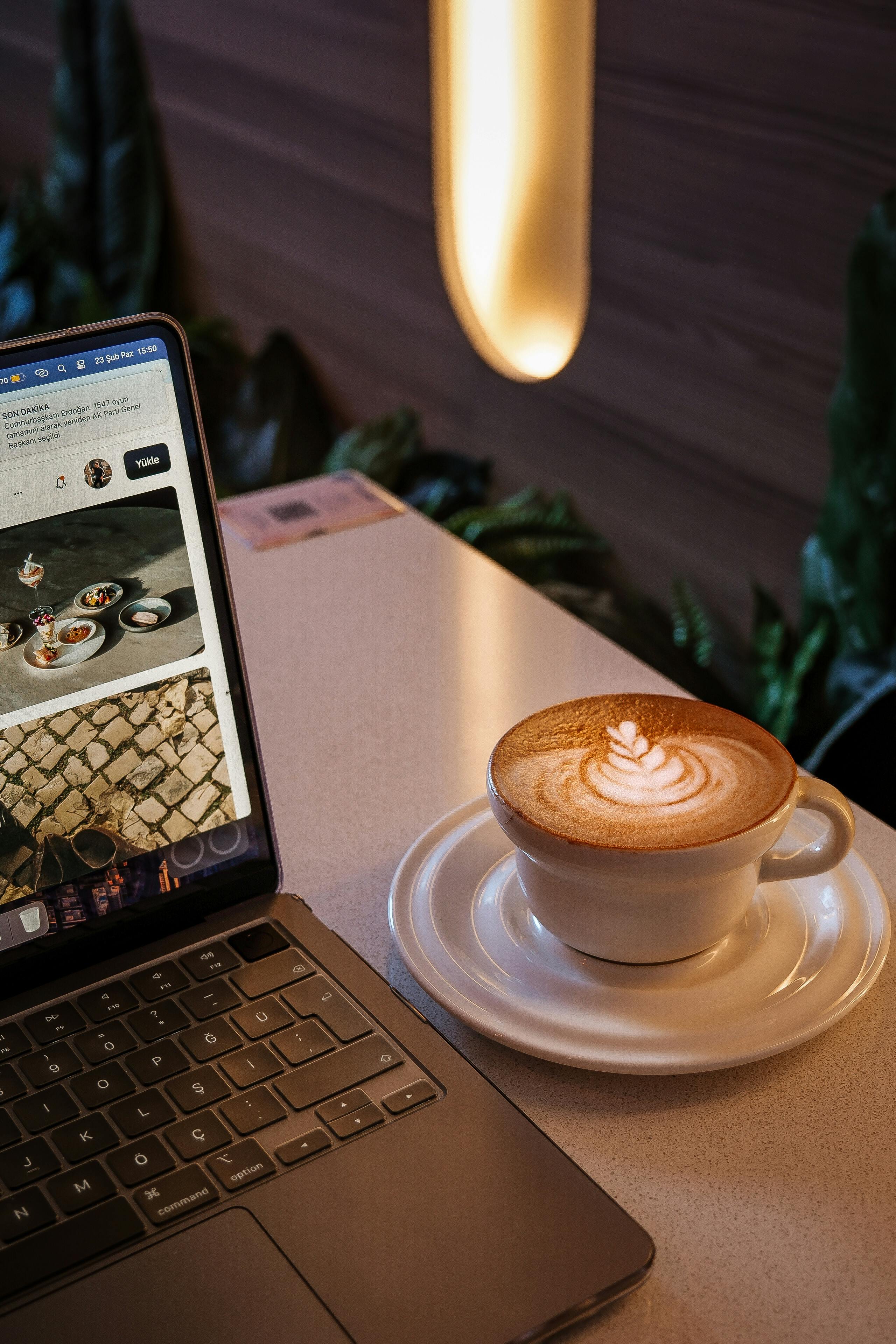 Cozy Workspace with Laptop and Latte Art Coffee · Free Stock Photo