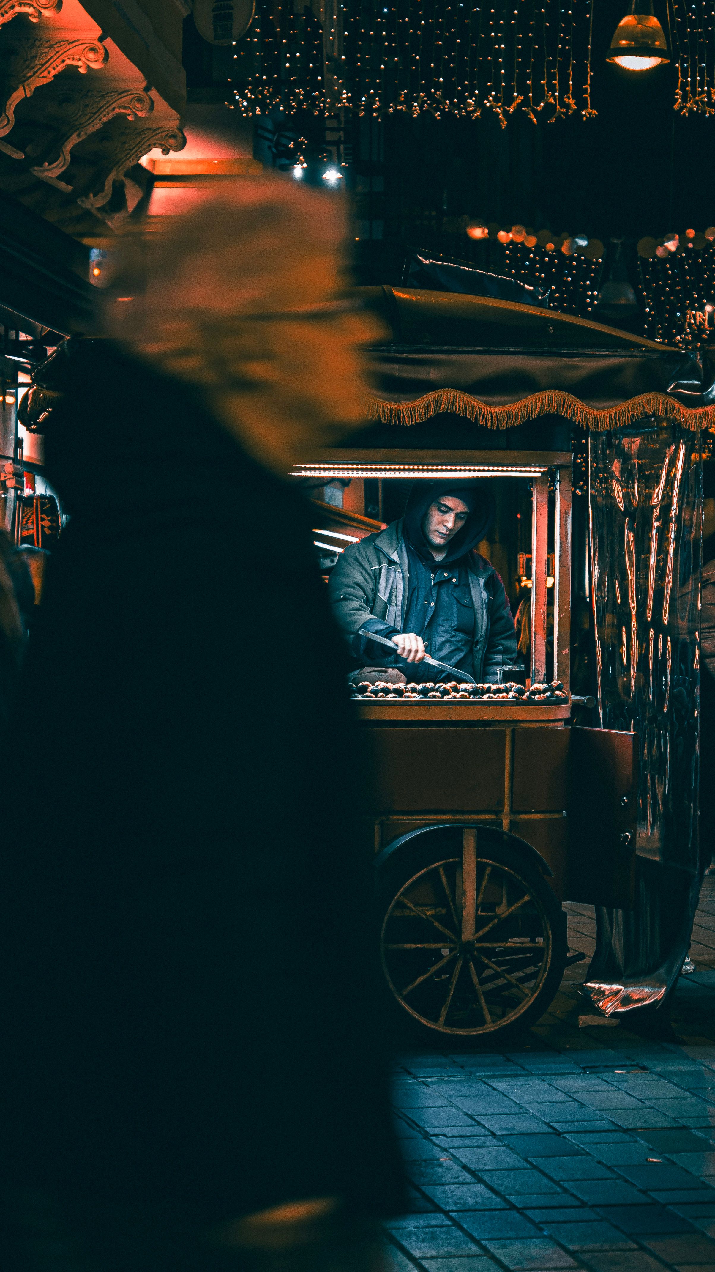 Street Vendor at Night Market Stall with Lights · Free Stock Photo