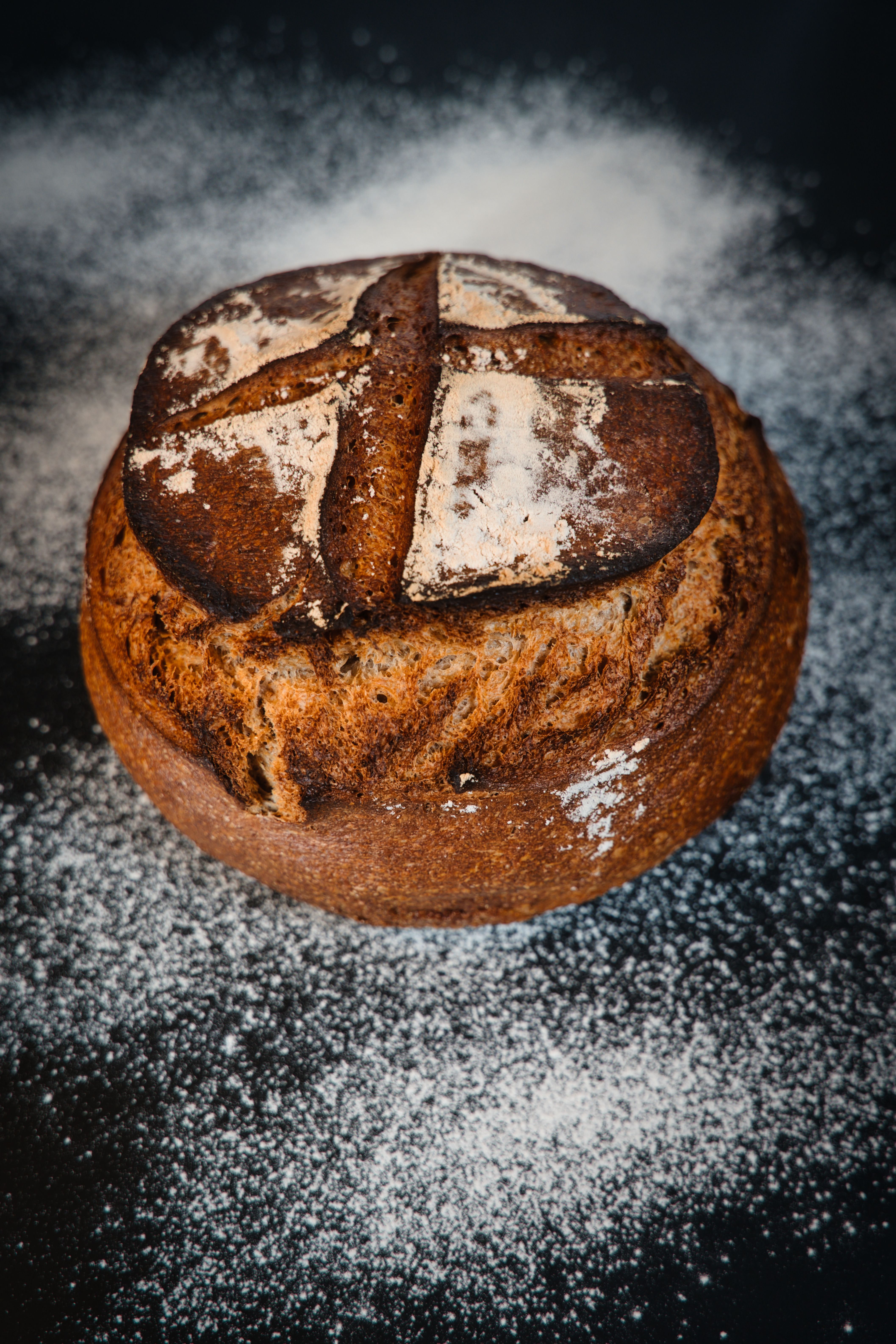 Rustic Artisan Bread Loaf in Dark Setting · Free Stock Photo
