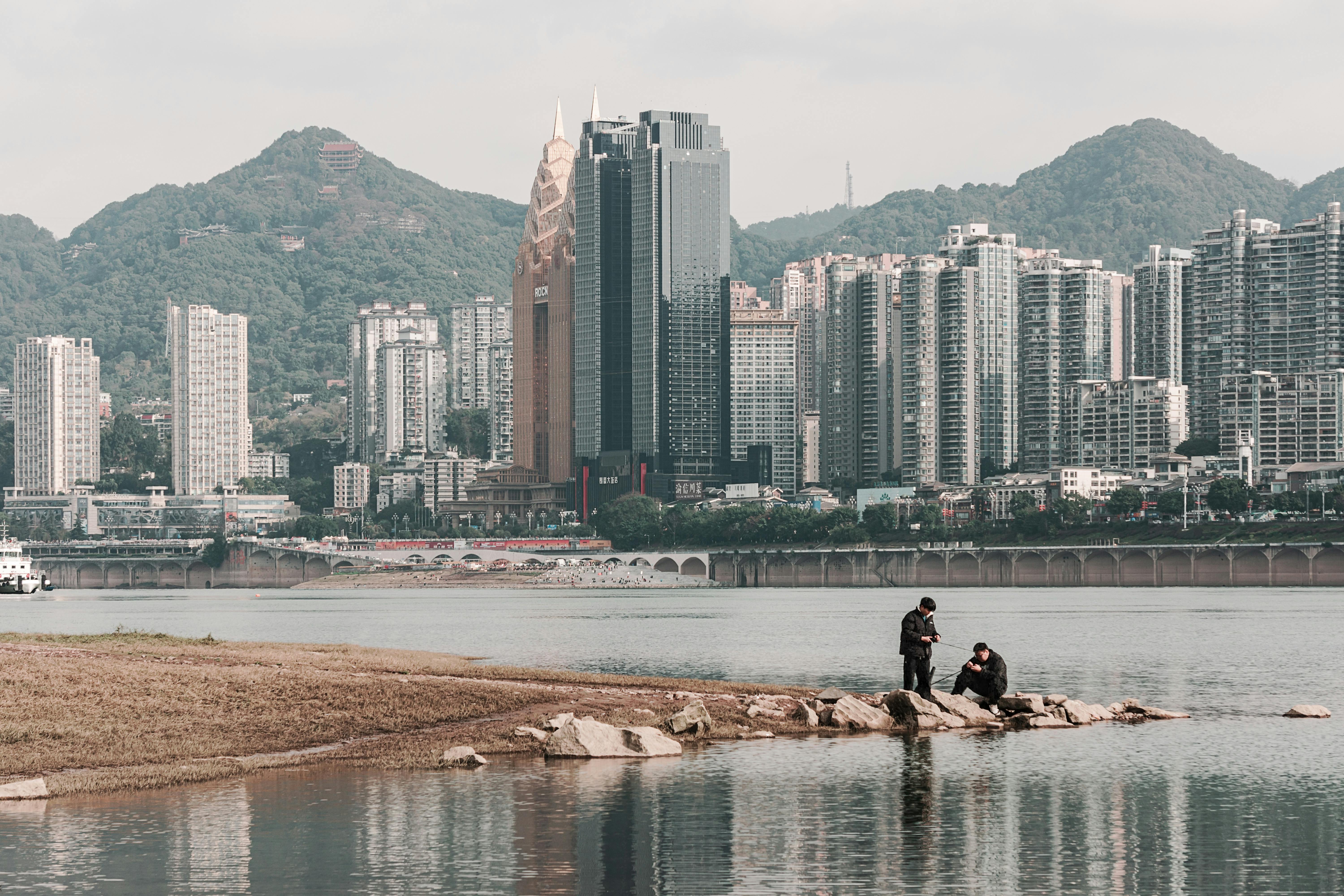 Urban Riverfront with Modern City Skyline · Free Stock Photo