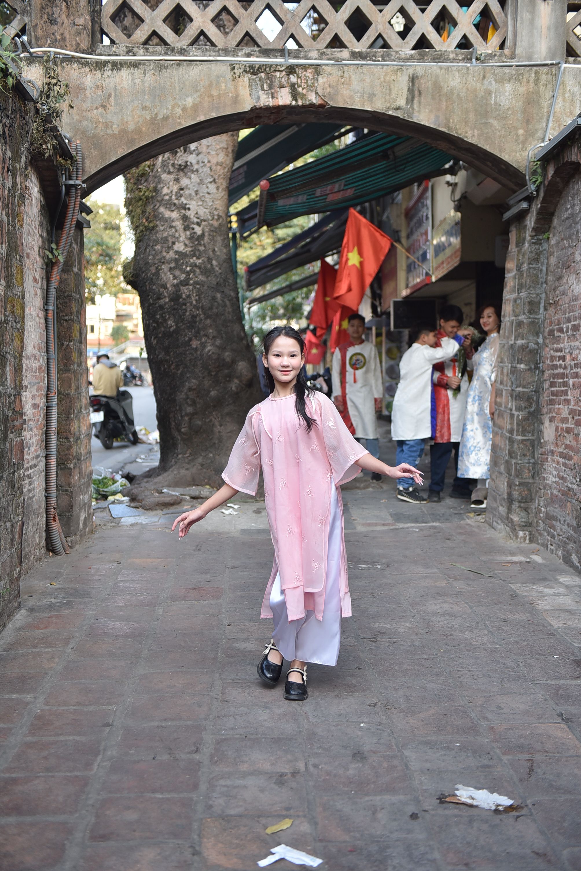 Young Girl in Traditional Outfit under Archway · Free Stock Photo