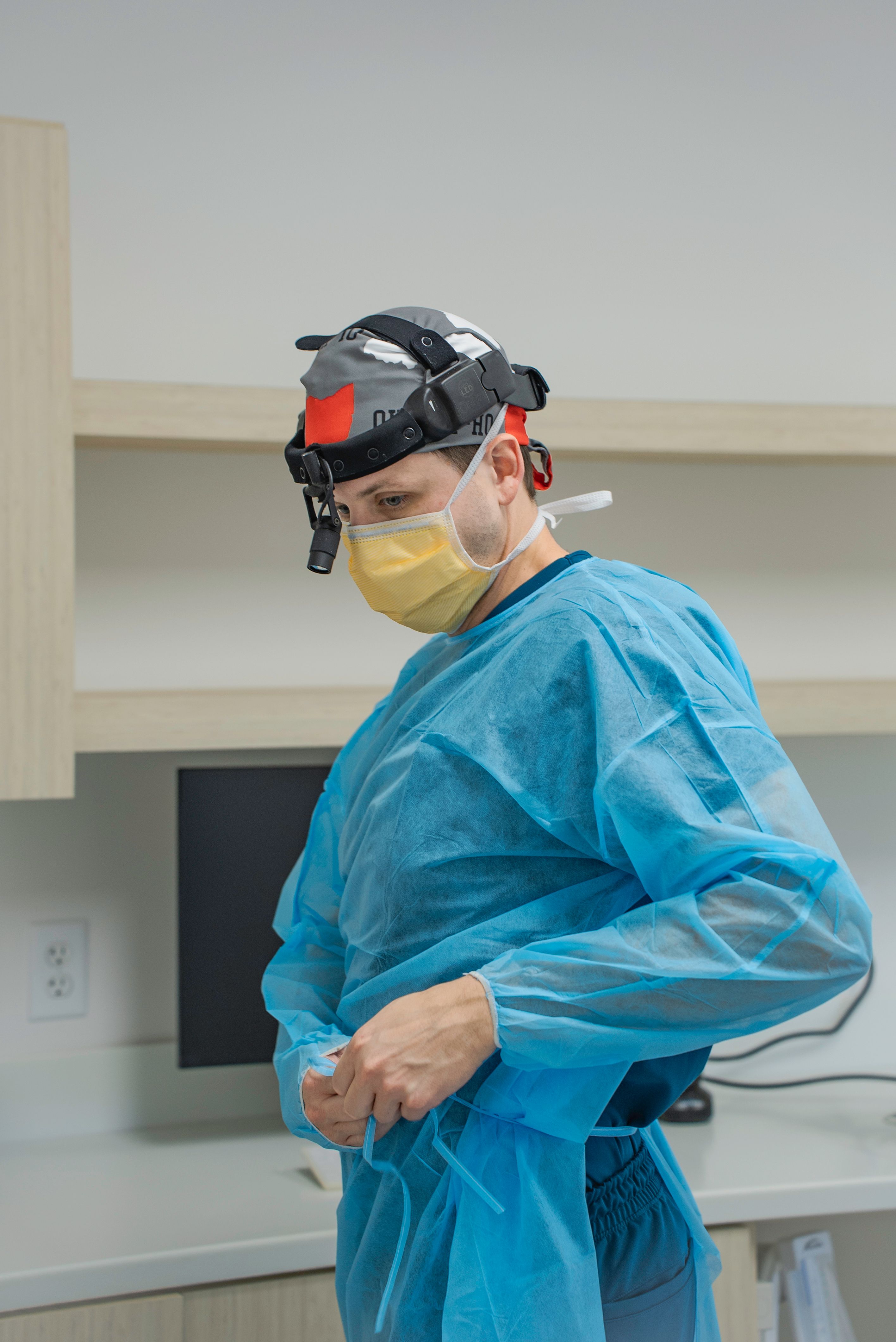 Dental Professional in PPE Kit Adjusting Scrubs · Free Stock Photo