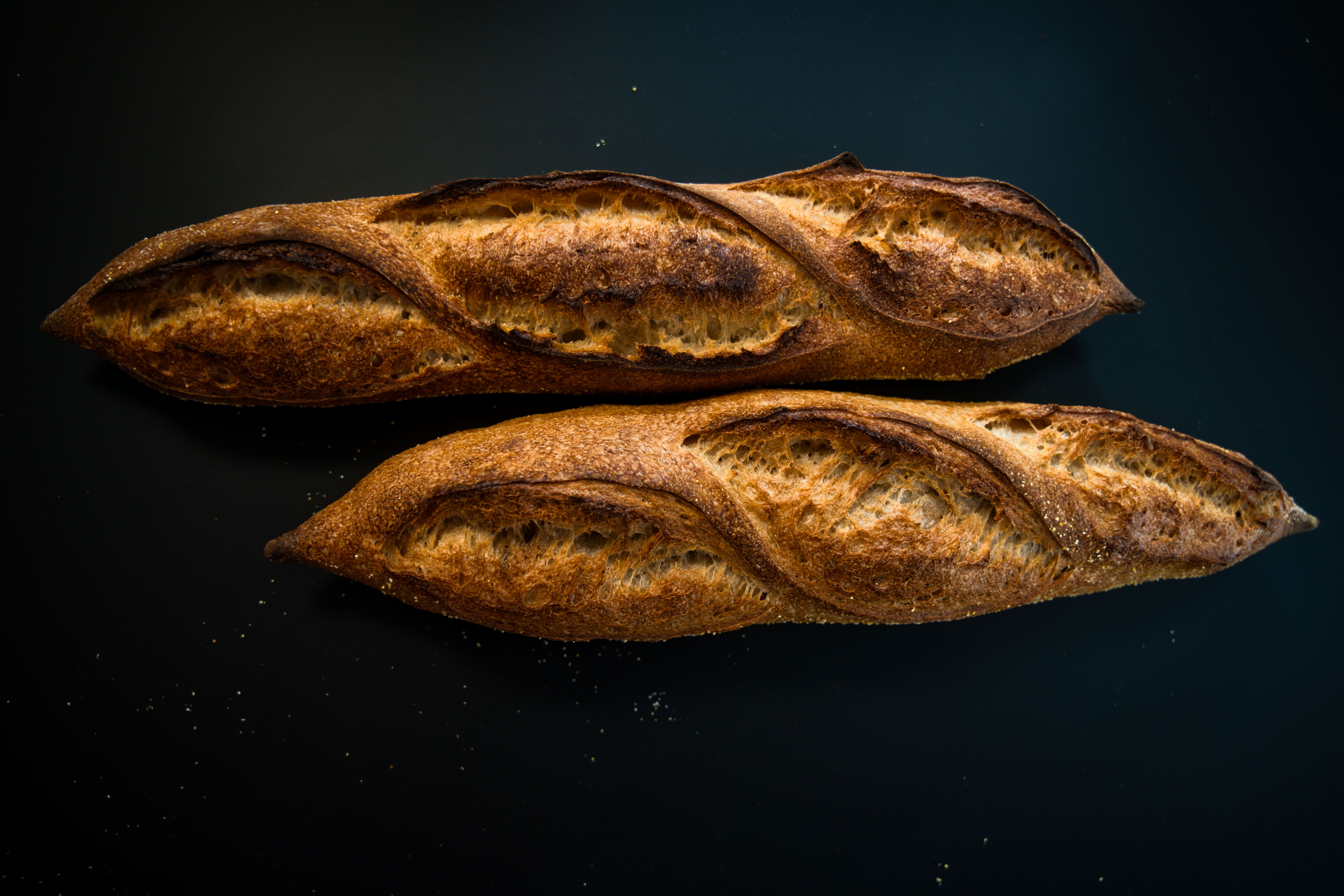 Rustic Artisanal Baguettes on Dark Background · Free Stock Photo
