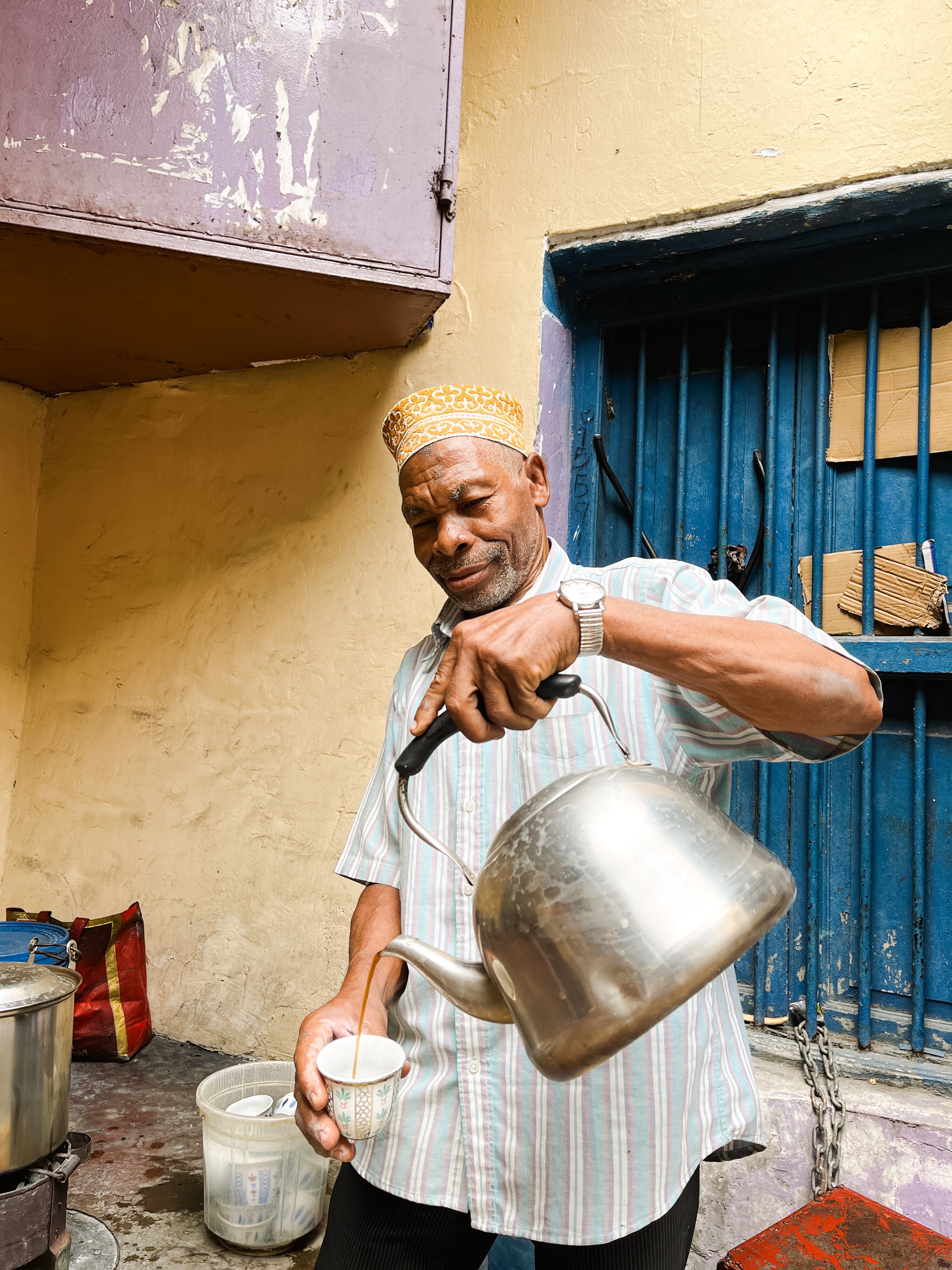 Man Pouring Tea Outdoors in Urban Setting · Free Stock Photo