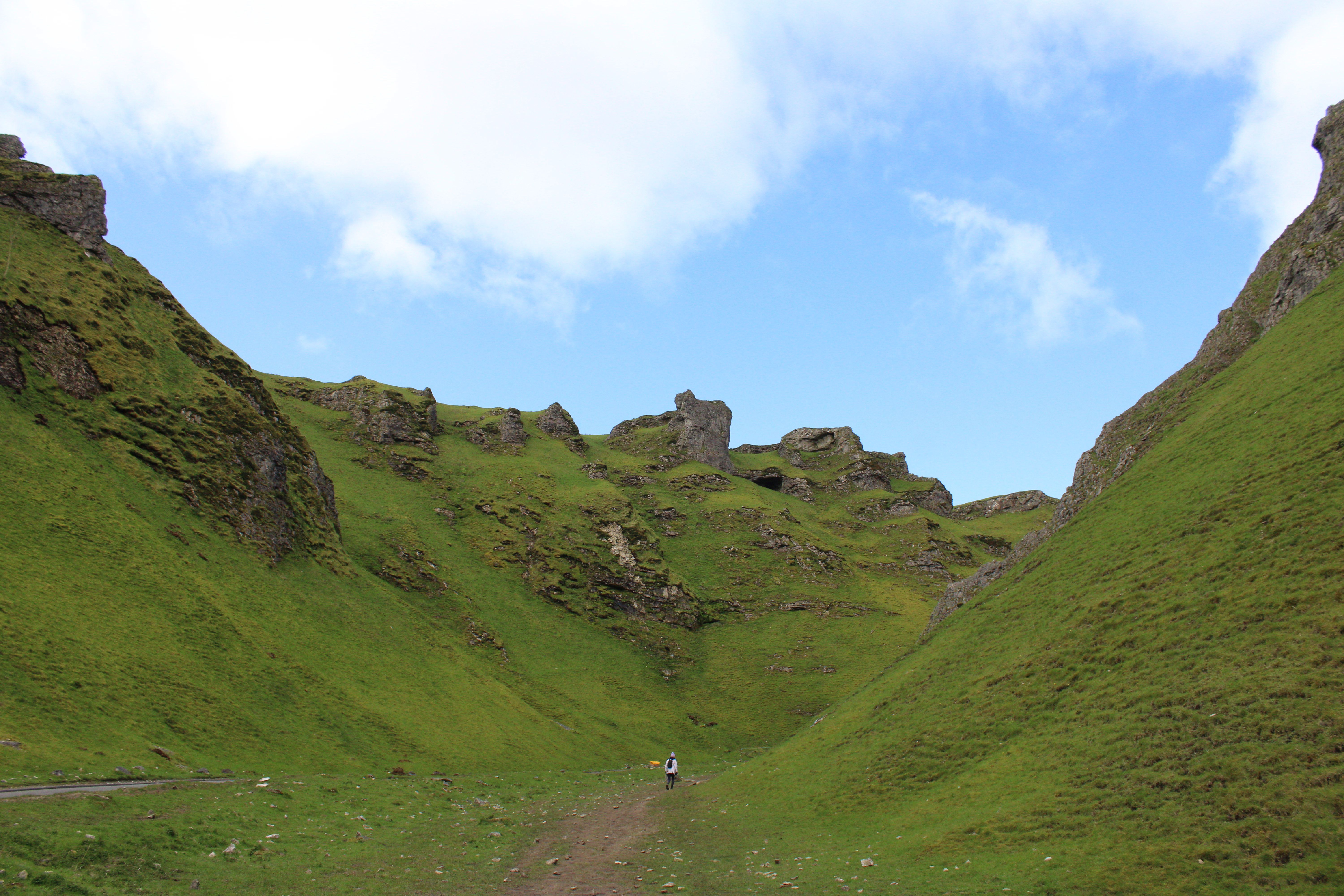 Dramatic Green Valley with Rocky Cliffs and Blue Sky · Free Stock Photo