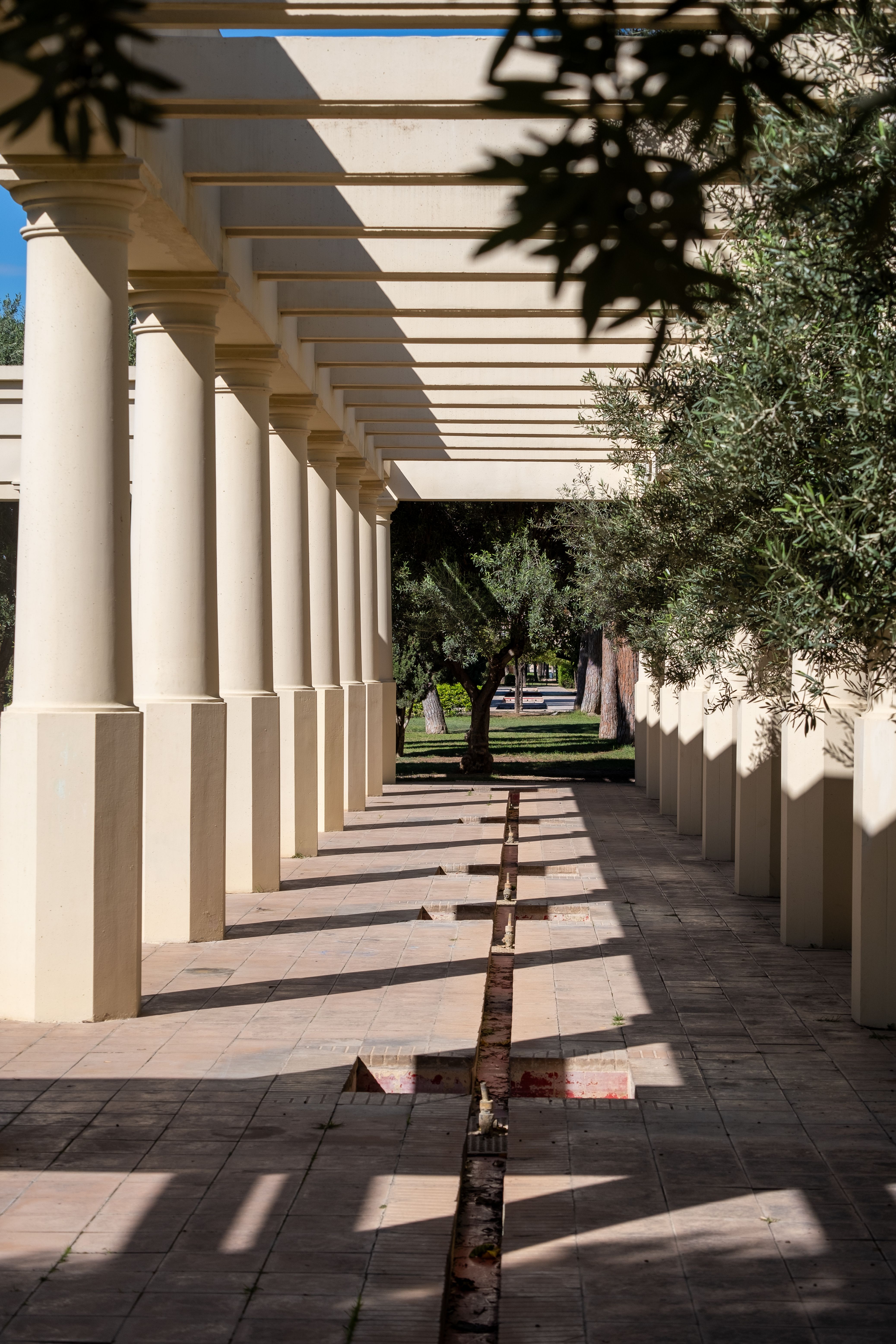 Architectural walkway with columns in park · Free Stock Photo