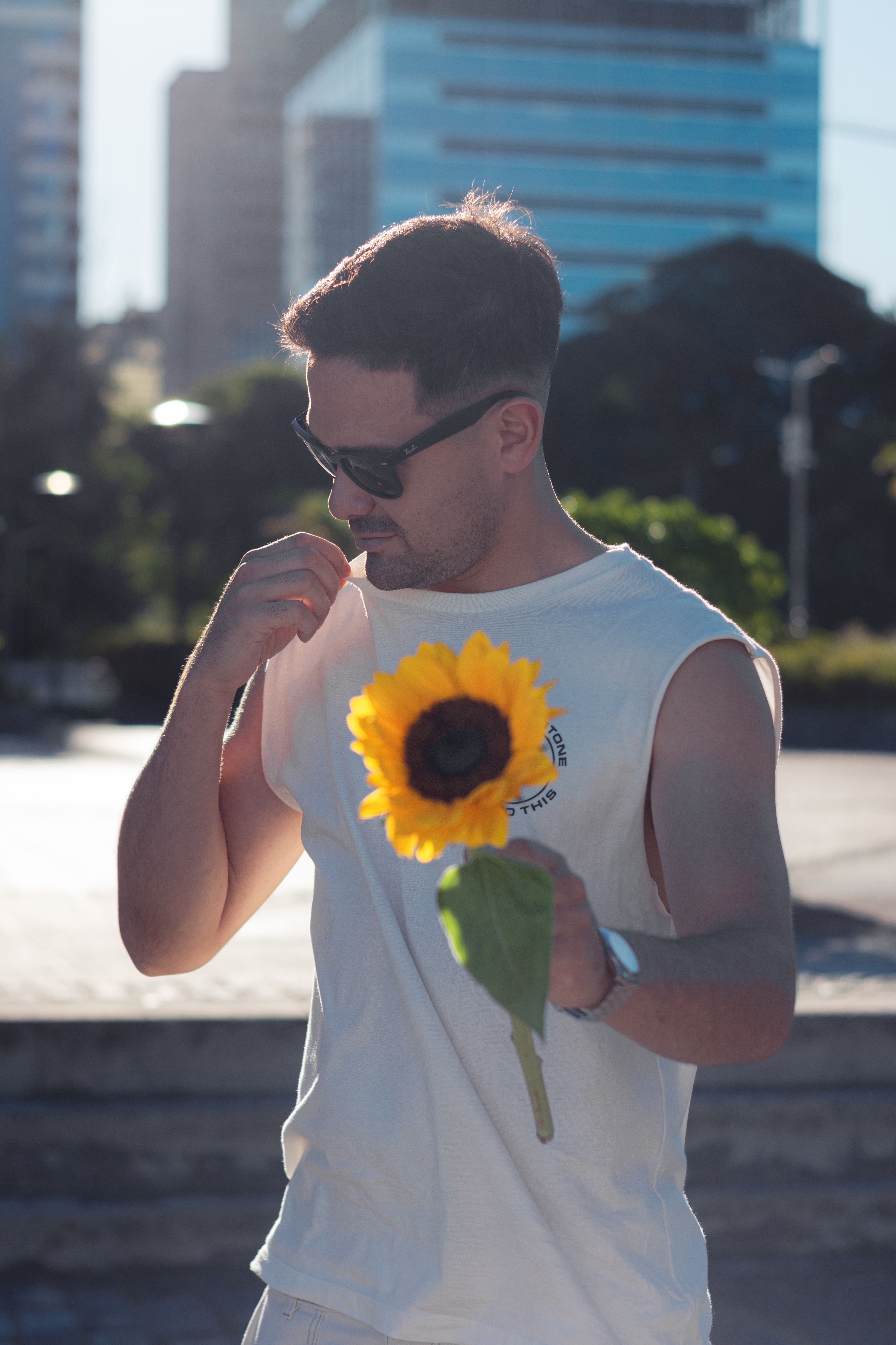 Man Holding Sunflower in Urban Buenos Aires · Free Stock Photo