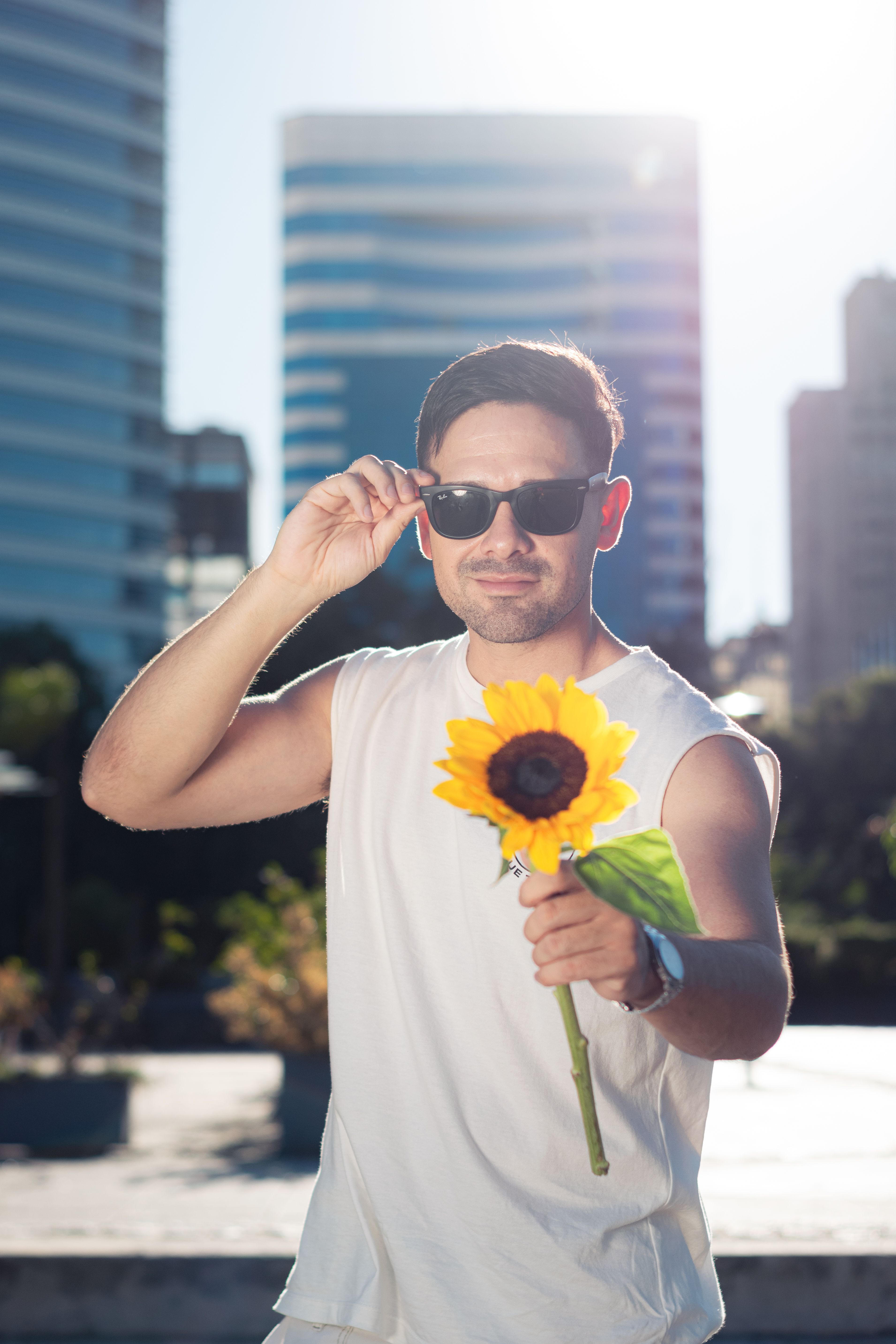 Man Offering Sunflower in Buenos Aires Cityscape · Free Stock Photo