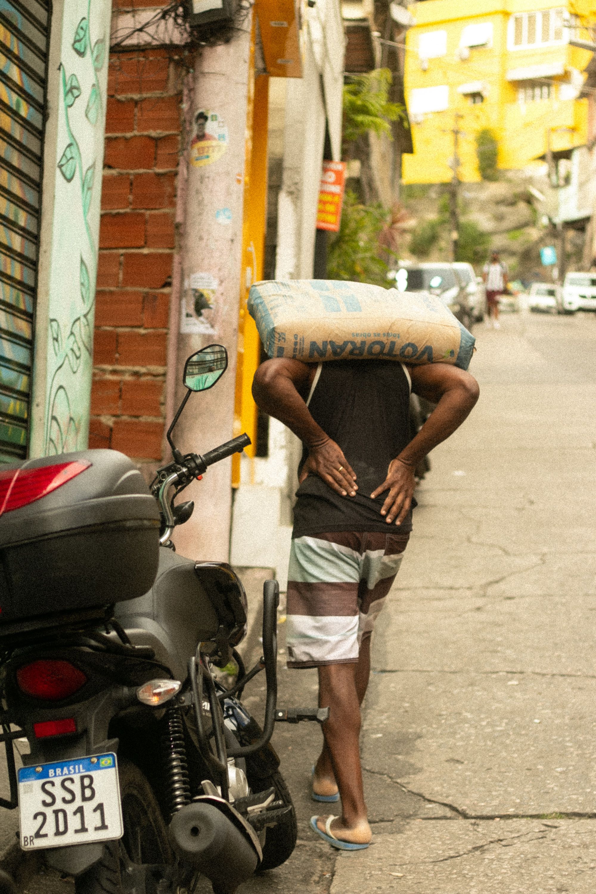 Hombre Cargando Saco De Cemento En Calle Urbana · Foto de stock gratuita