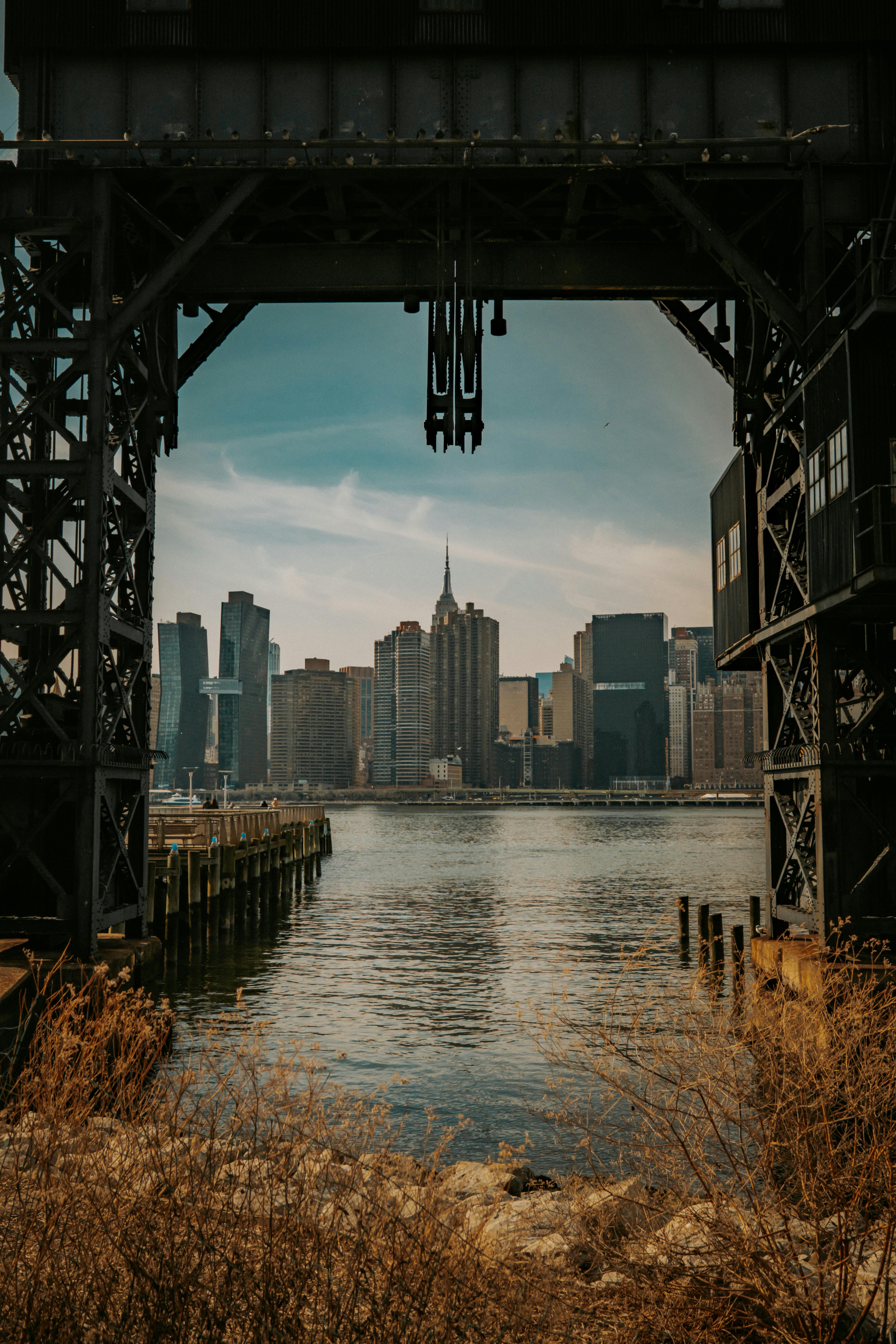 New York Skyline Framed by Industrial Architecture · Free Stock Photo