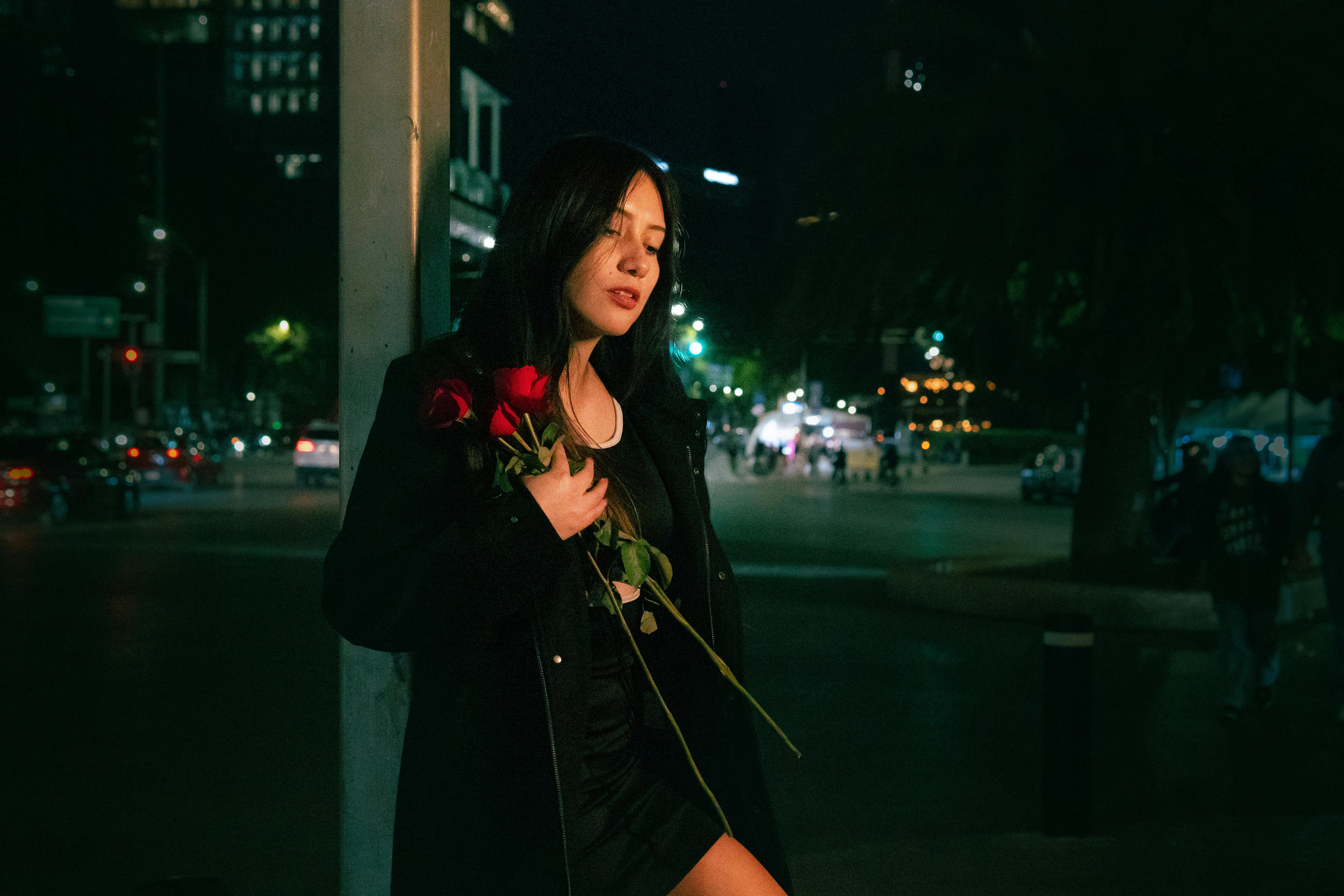 Woman with Roses at Night in Urban Setting · Free Stock Photo