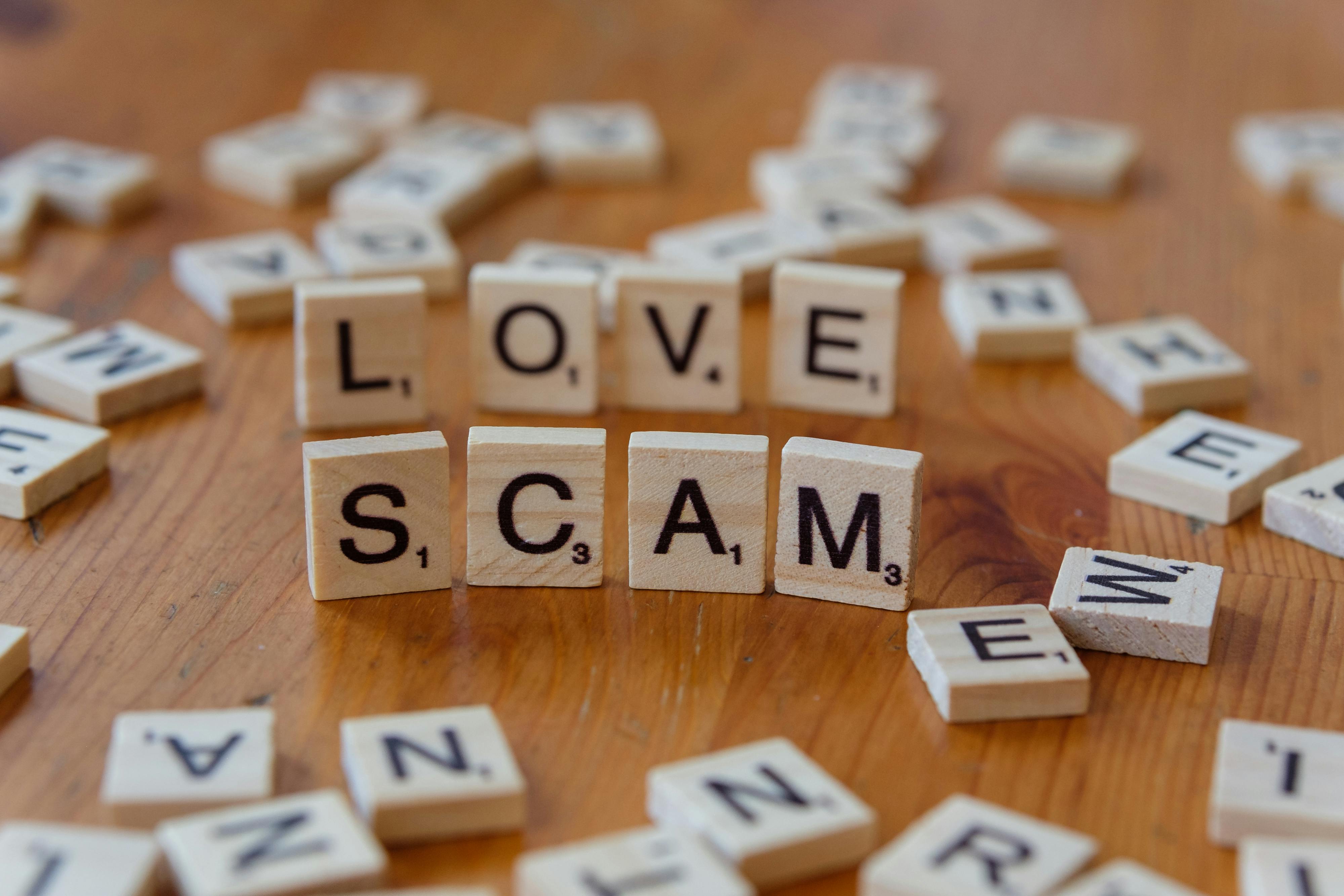 Scrabble Tiles Spell Out Love Scam on Table · Free Stock Photo