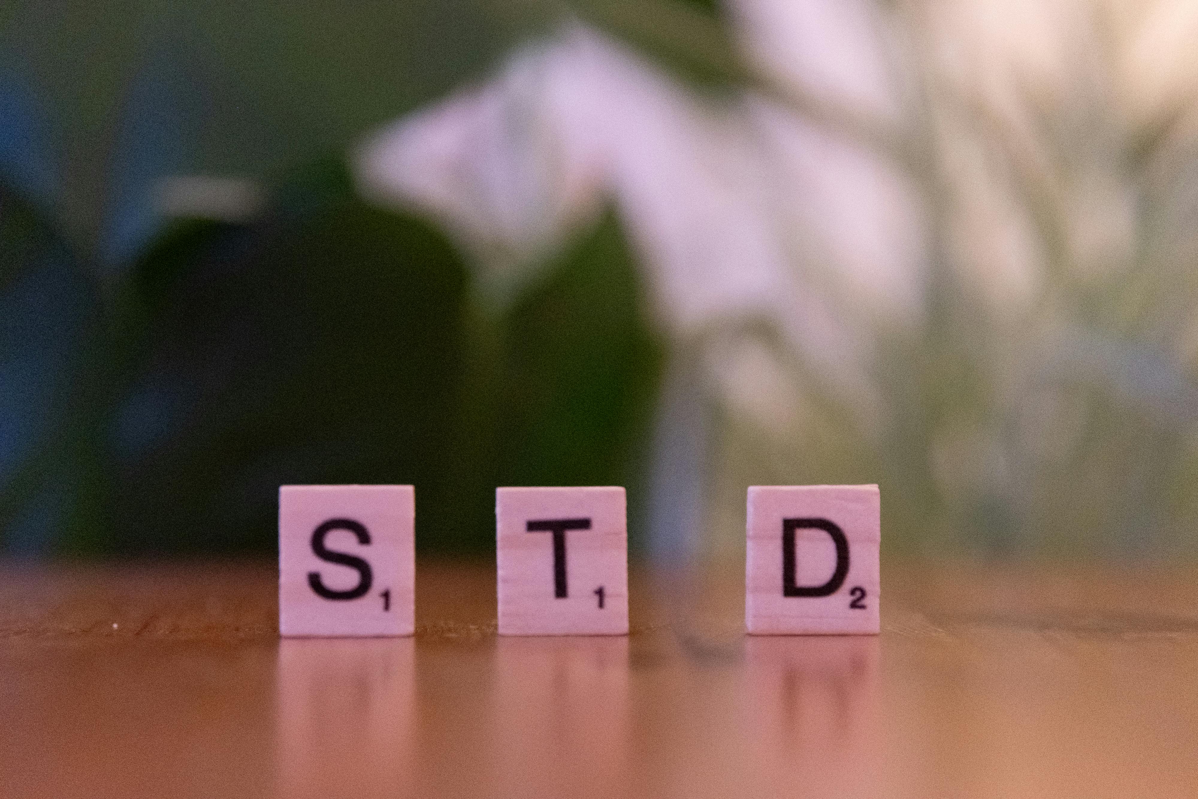 STD Awareness Scrabble Tiles on Wooden Surface · Free Stock Photo
