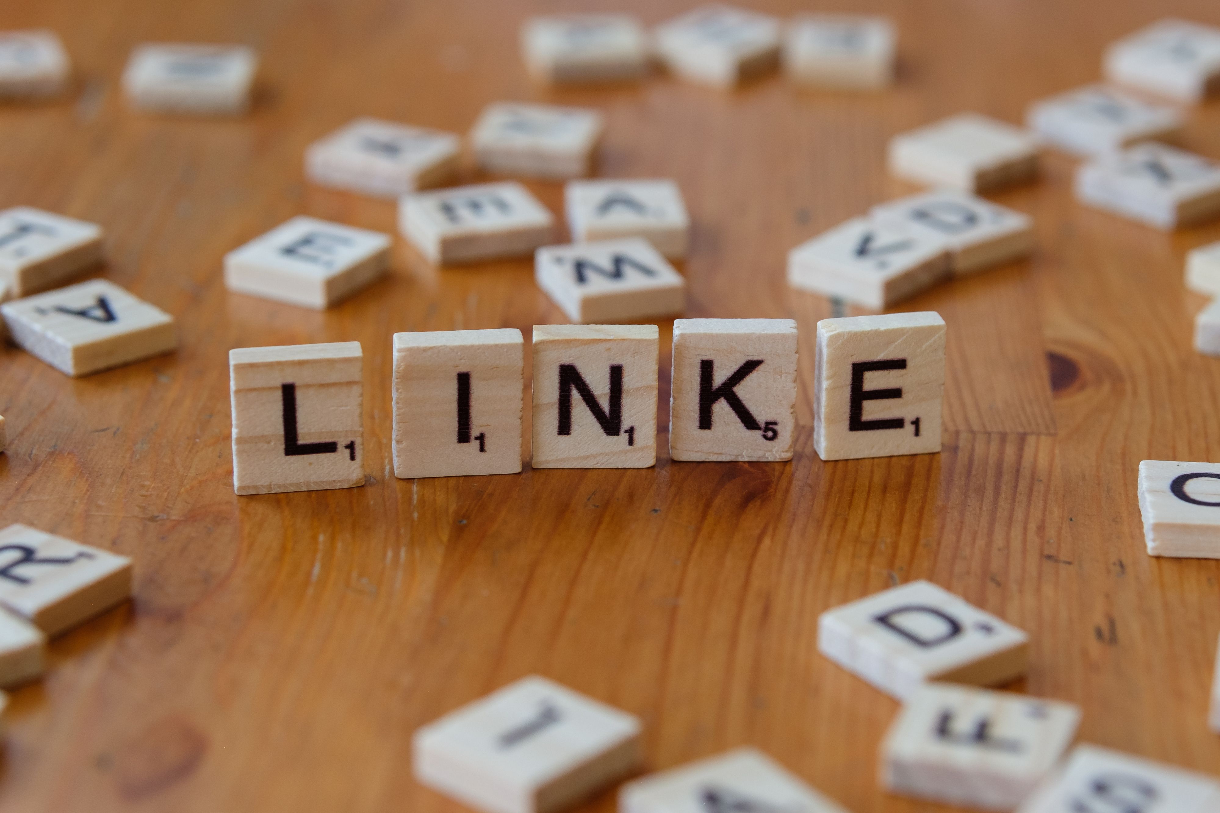 Wooden Scrabble Letters Spelling 'LINKE' on Table · Free Stock Photo