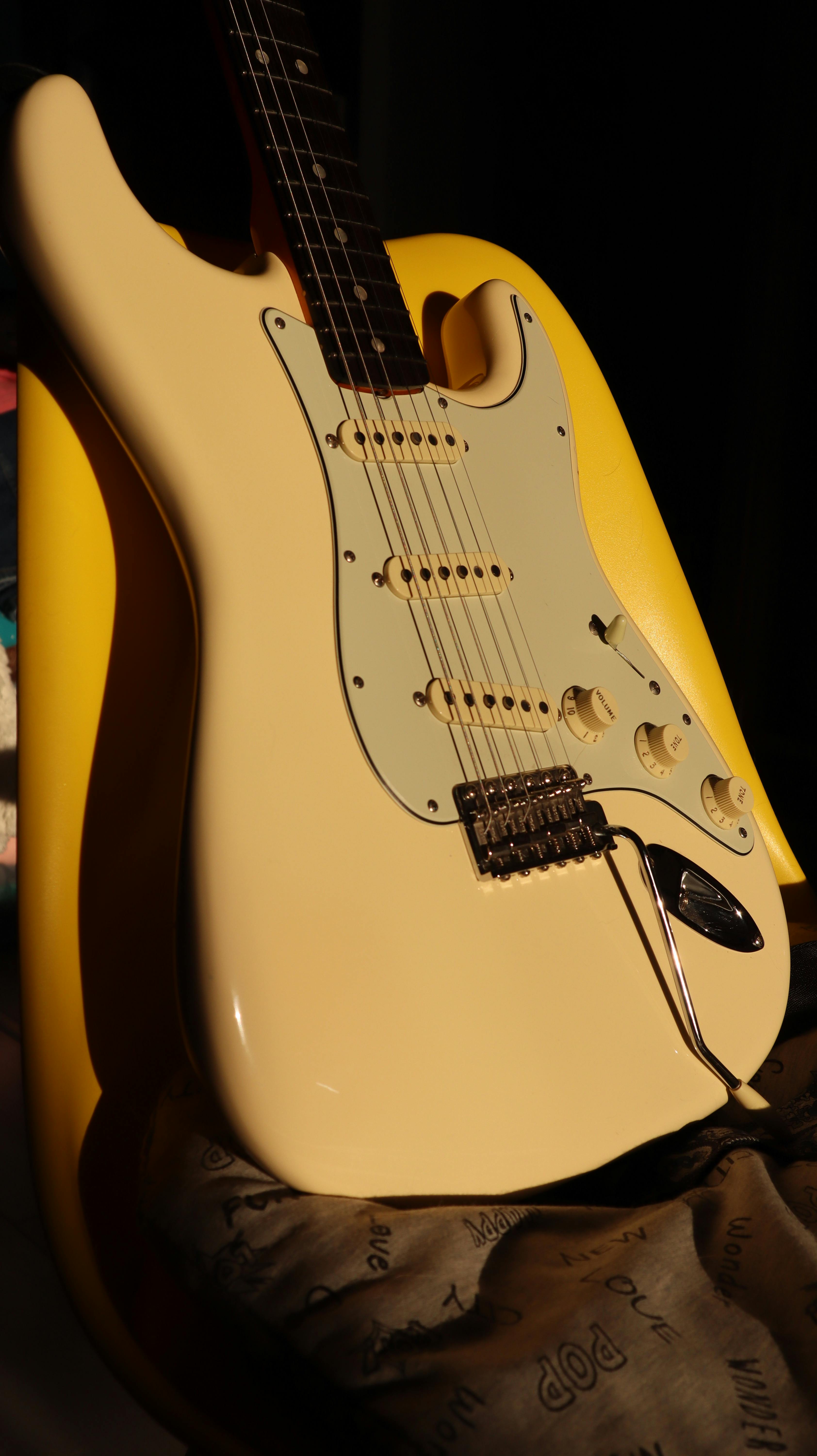 Cream Fender Stratocaster Guitar on Yellow Chair · Free Stock Photo