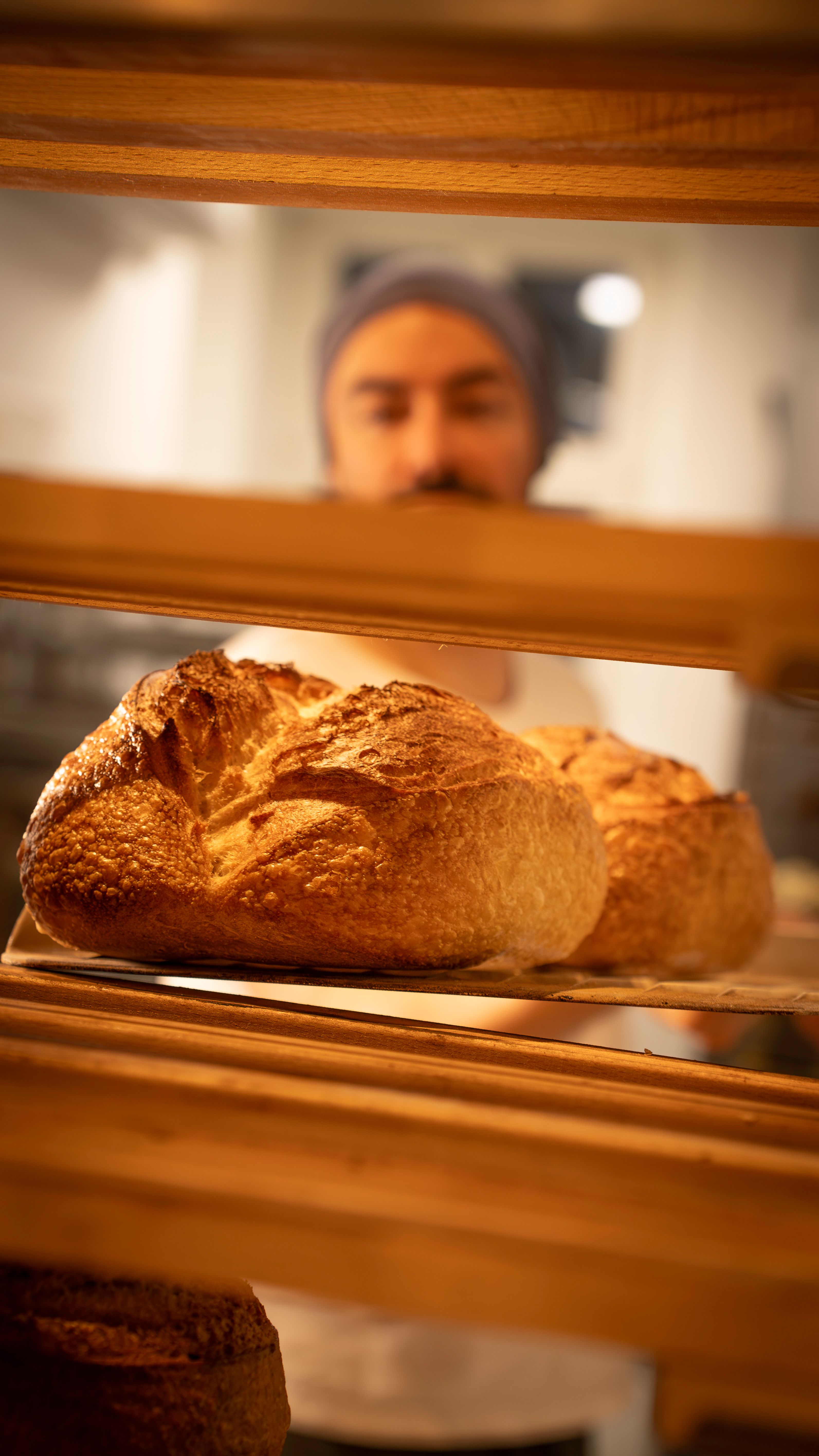 Artisan Baker Displaying Freshly Baked Bread · Free Stock Photo
