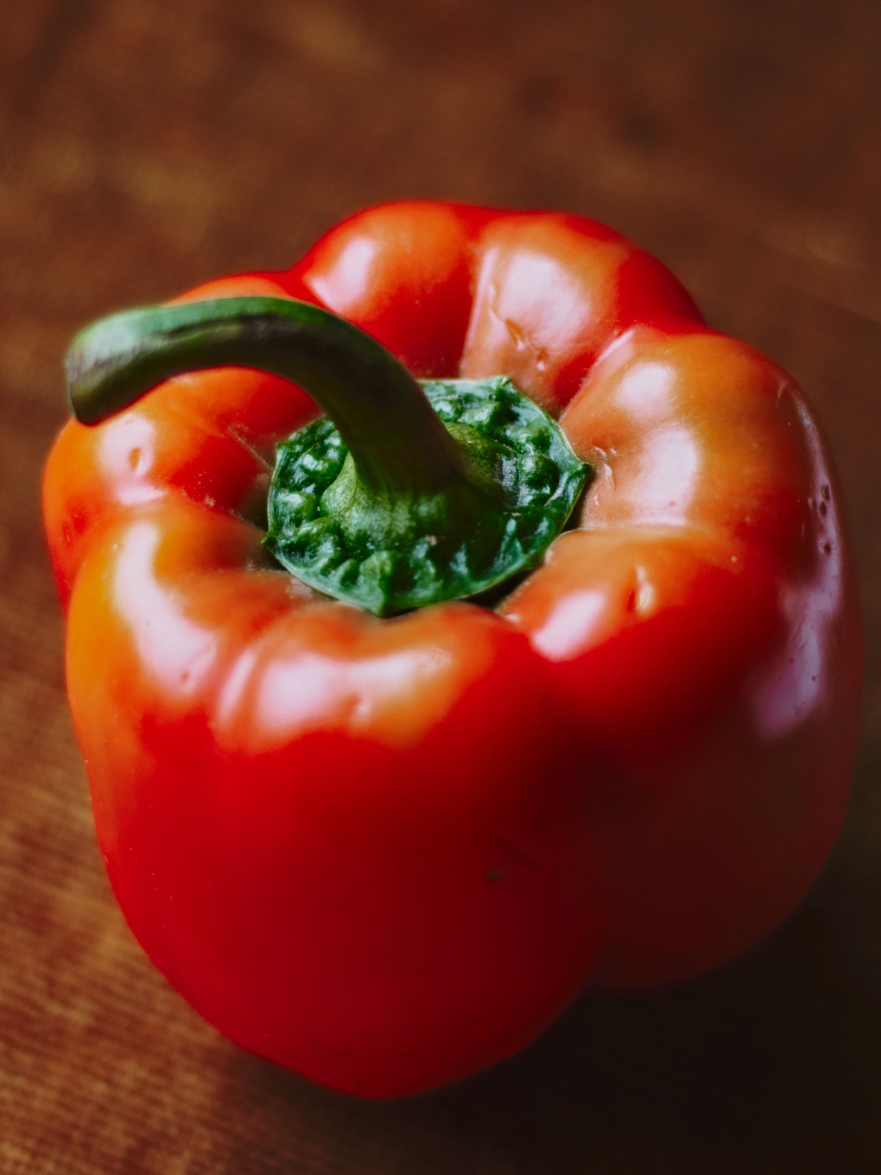 Fresh Red Bell Pepper on Rustic Surface · Free Stock Photo