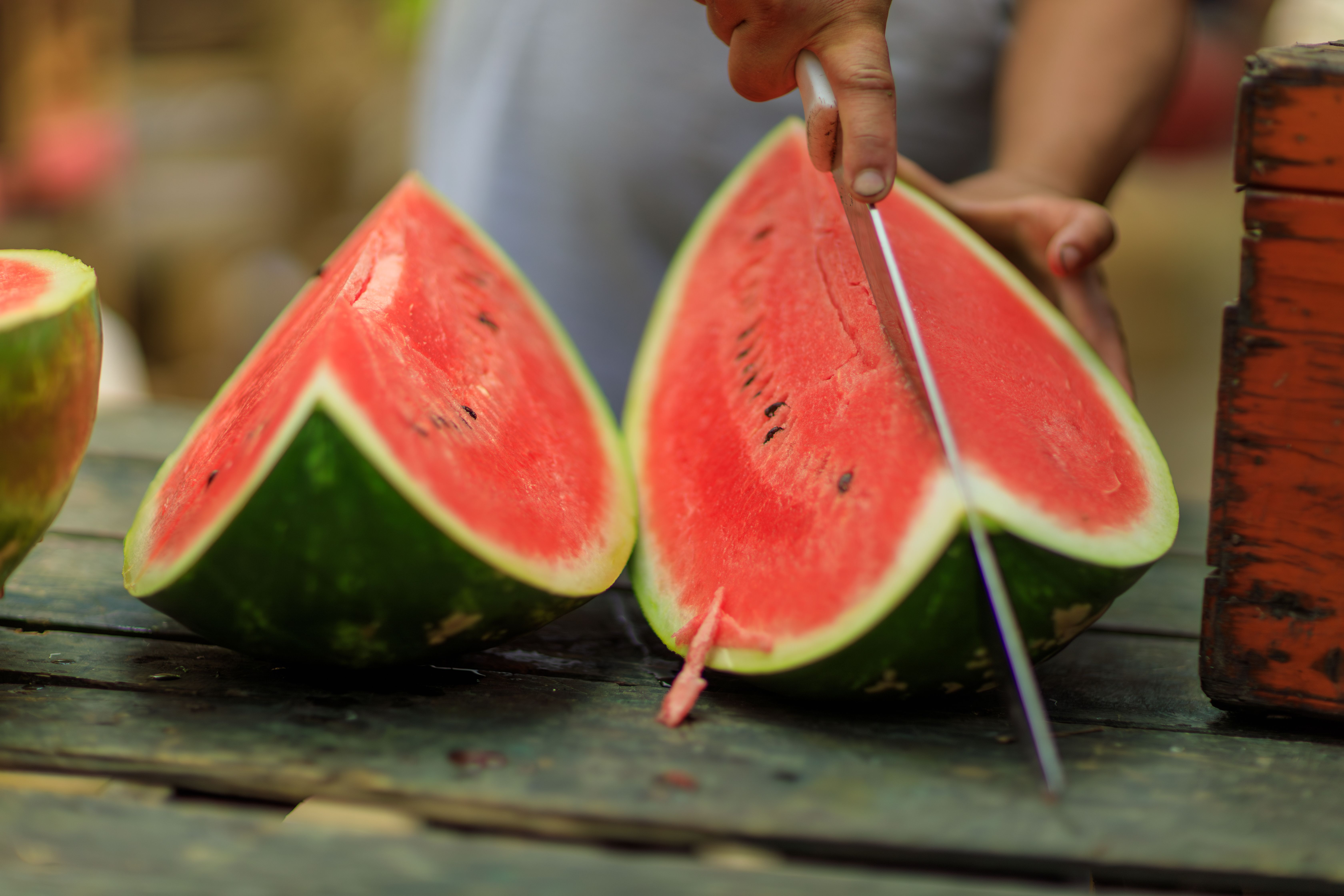 Fresh Watermelon Slices Being Cut Outdoors · Free Stock Photo