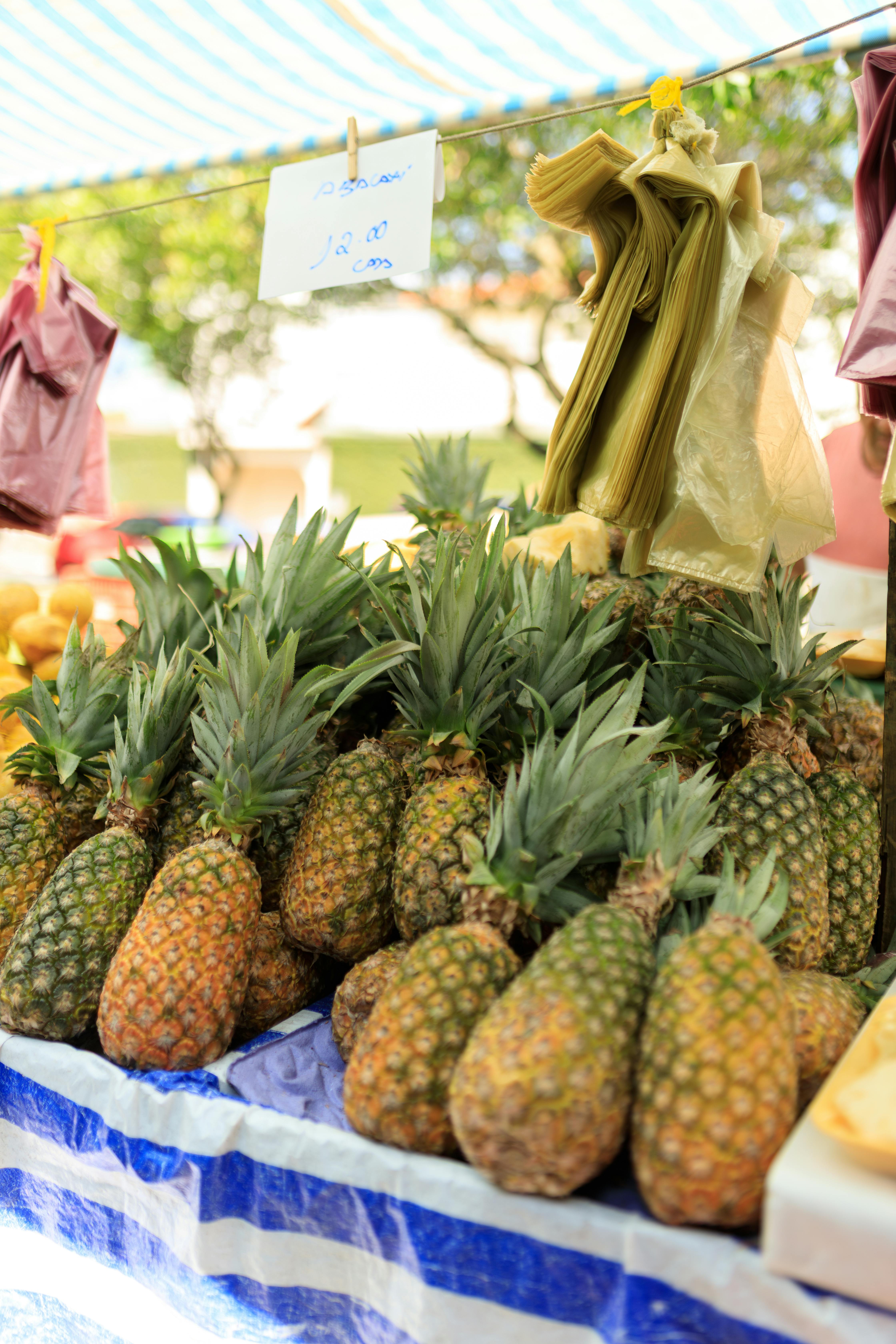 Vibrant Pineapples on Display at Outdoor Market · Free Stock Photo