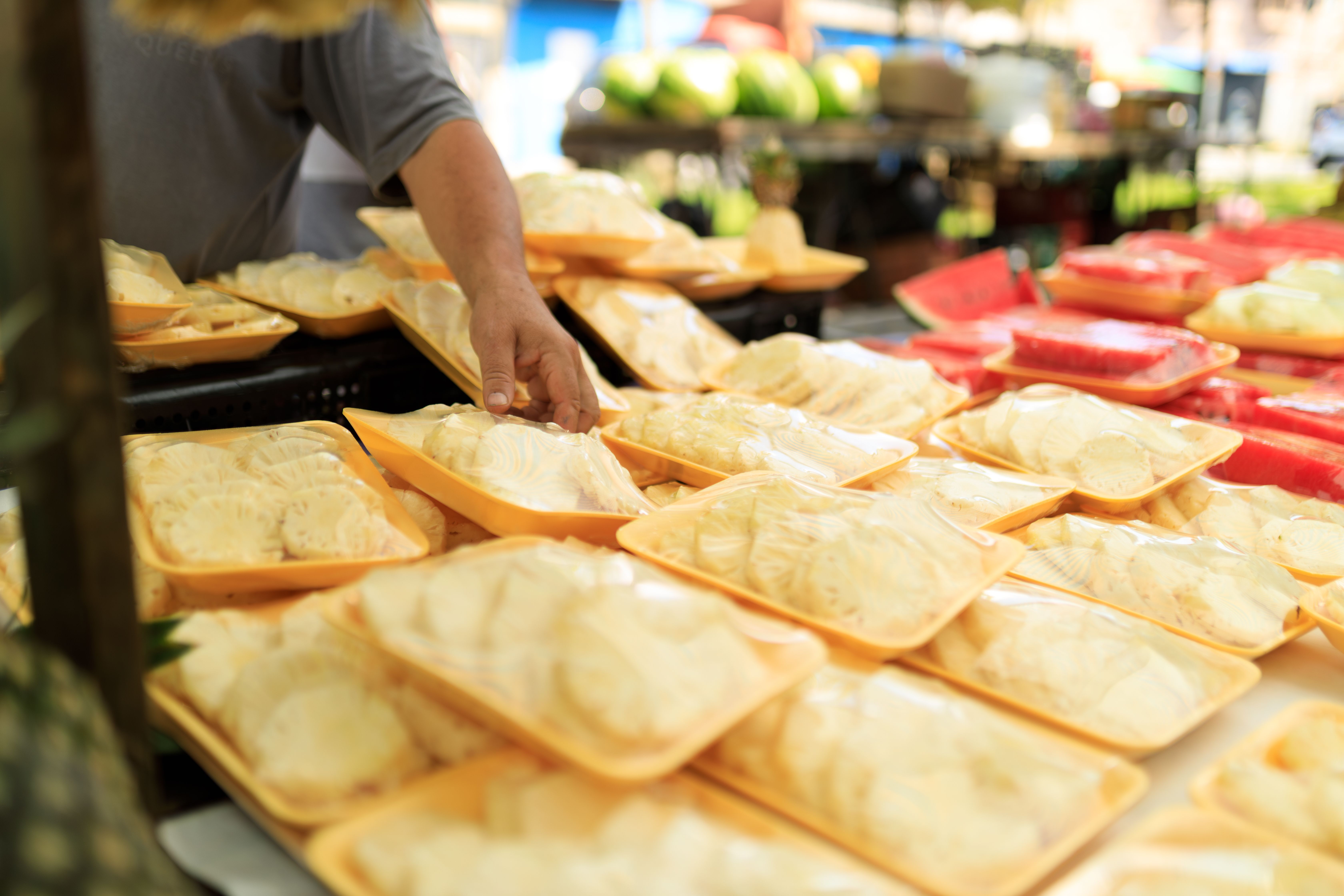 Person selecting fresh packaged food at outdoor market · Free Stock Photo