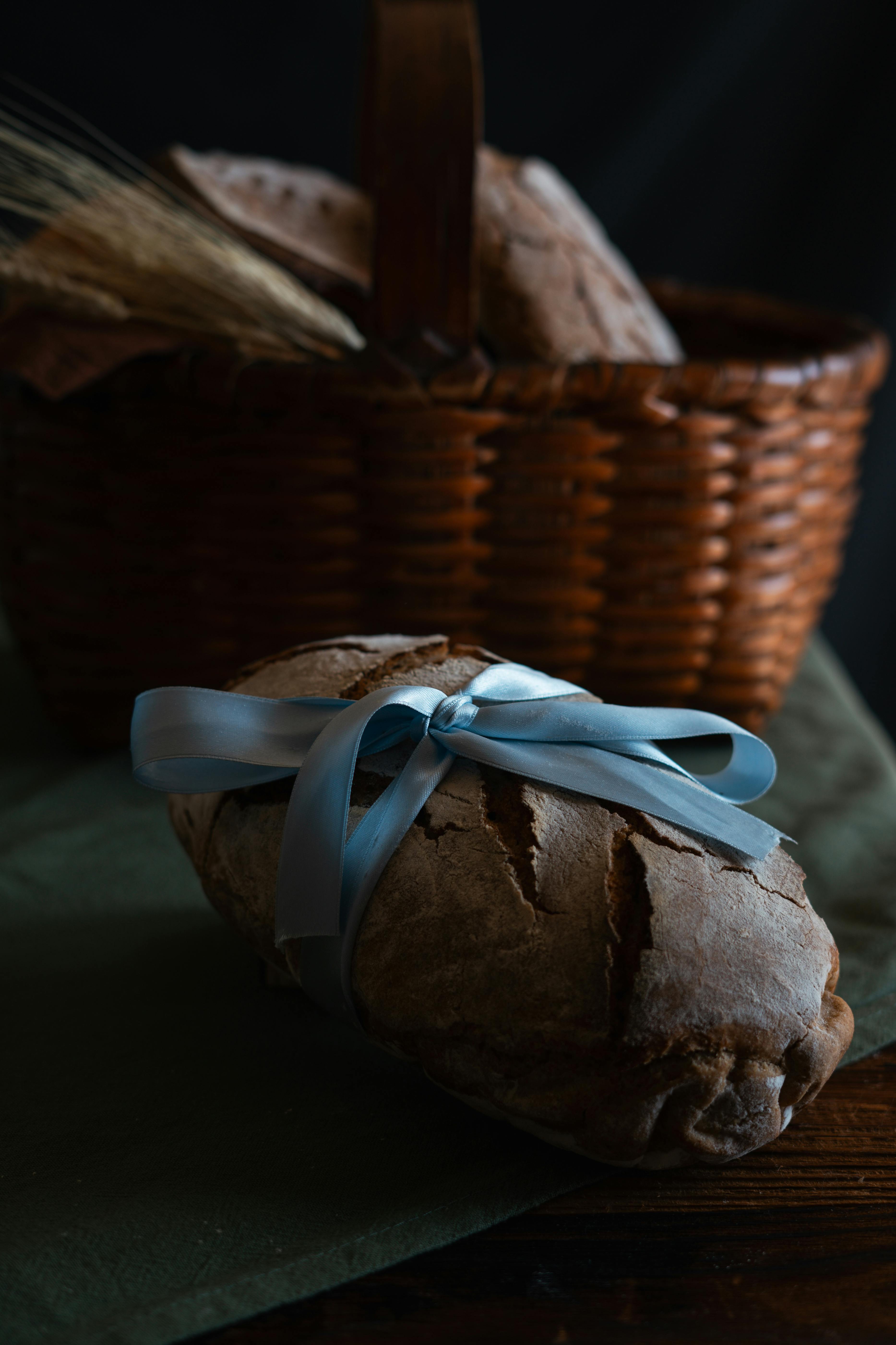 Rustic Bread Loaf with Blue Ribbon in Basket · Free Stock Photo