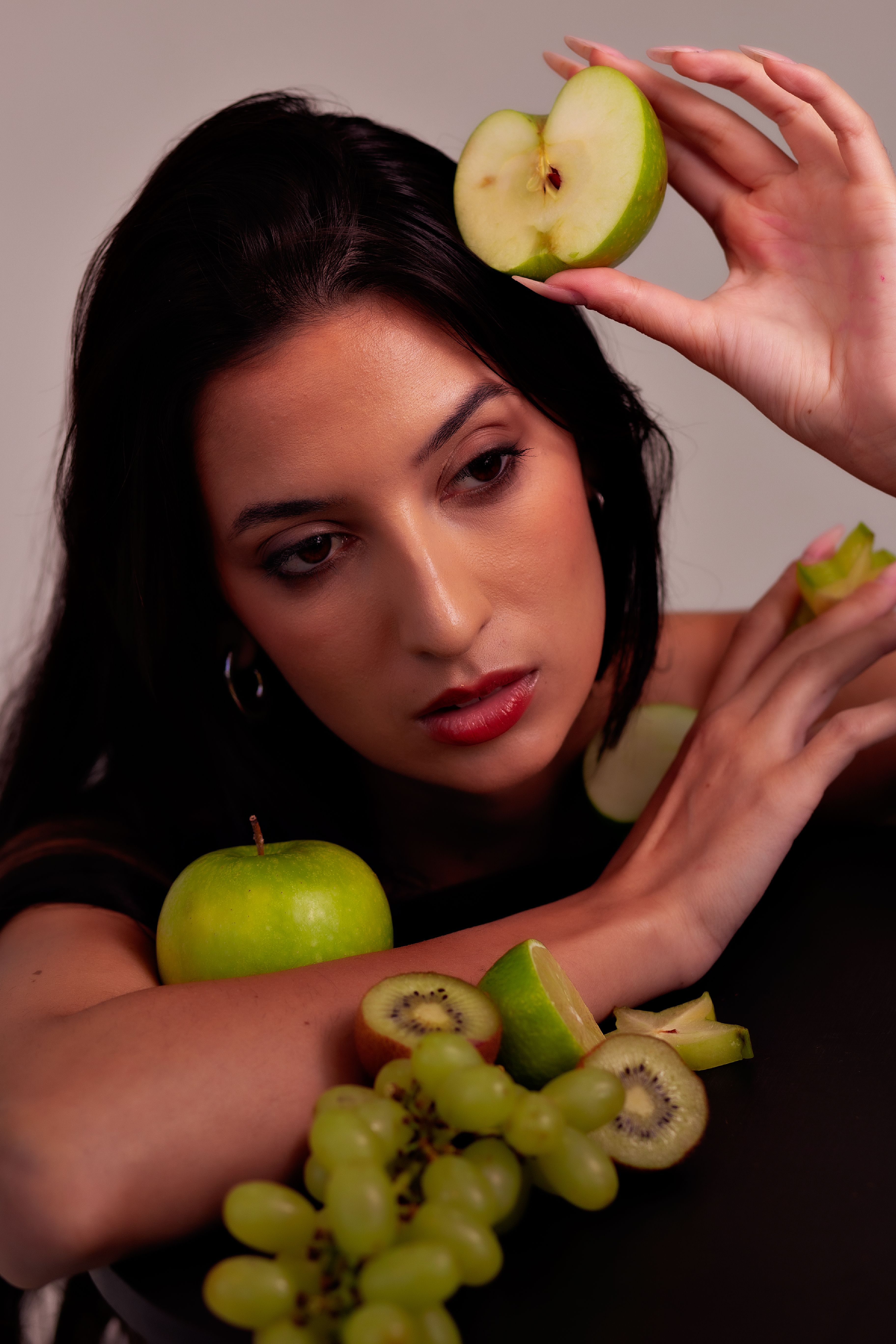 Woman Posing with Green Fruits in Artistic Portrait · Free Stock Photo