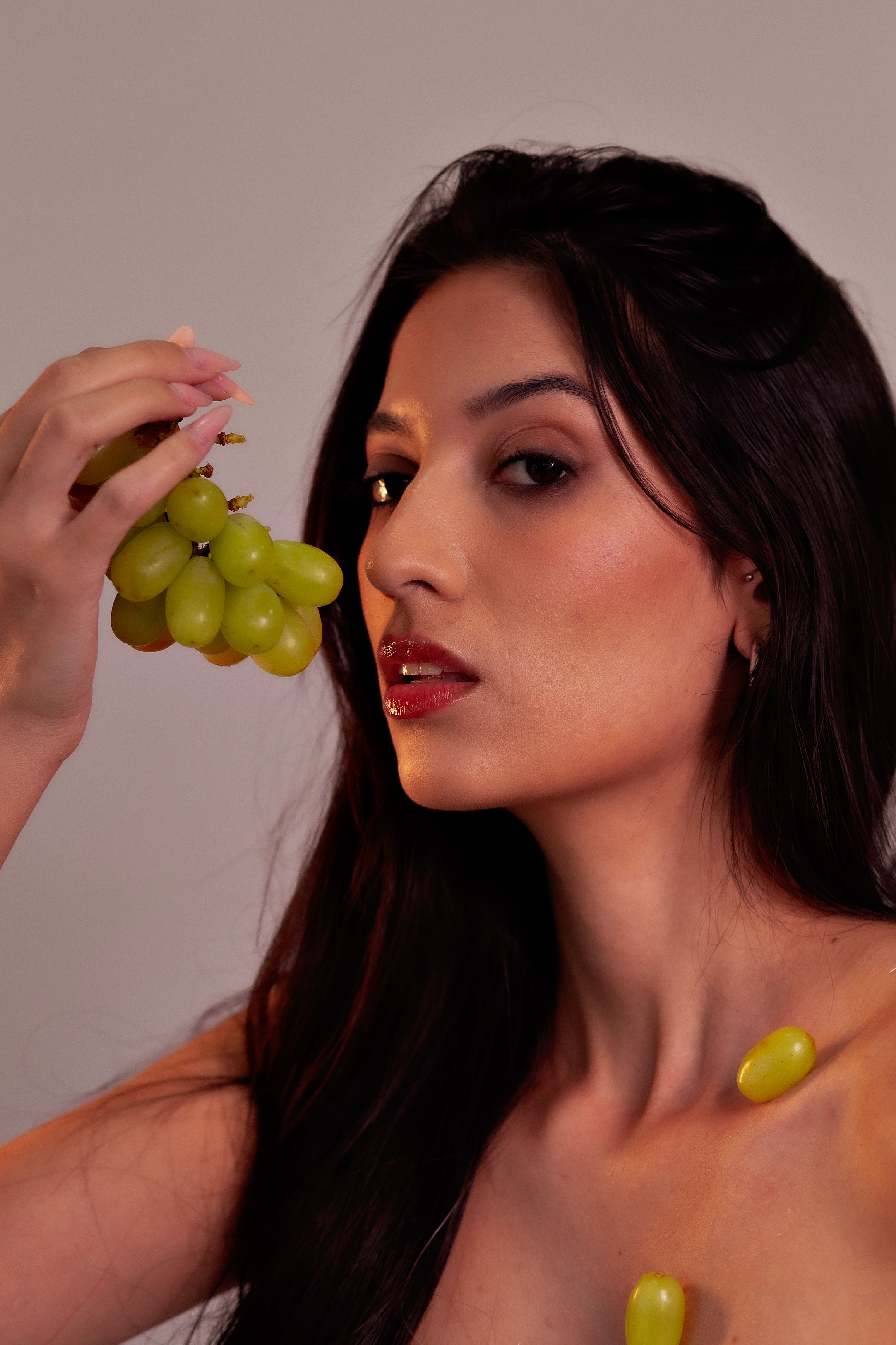 Artistic Portrait with Grapes in Studio Setting · Free Stock Photo