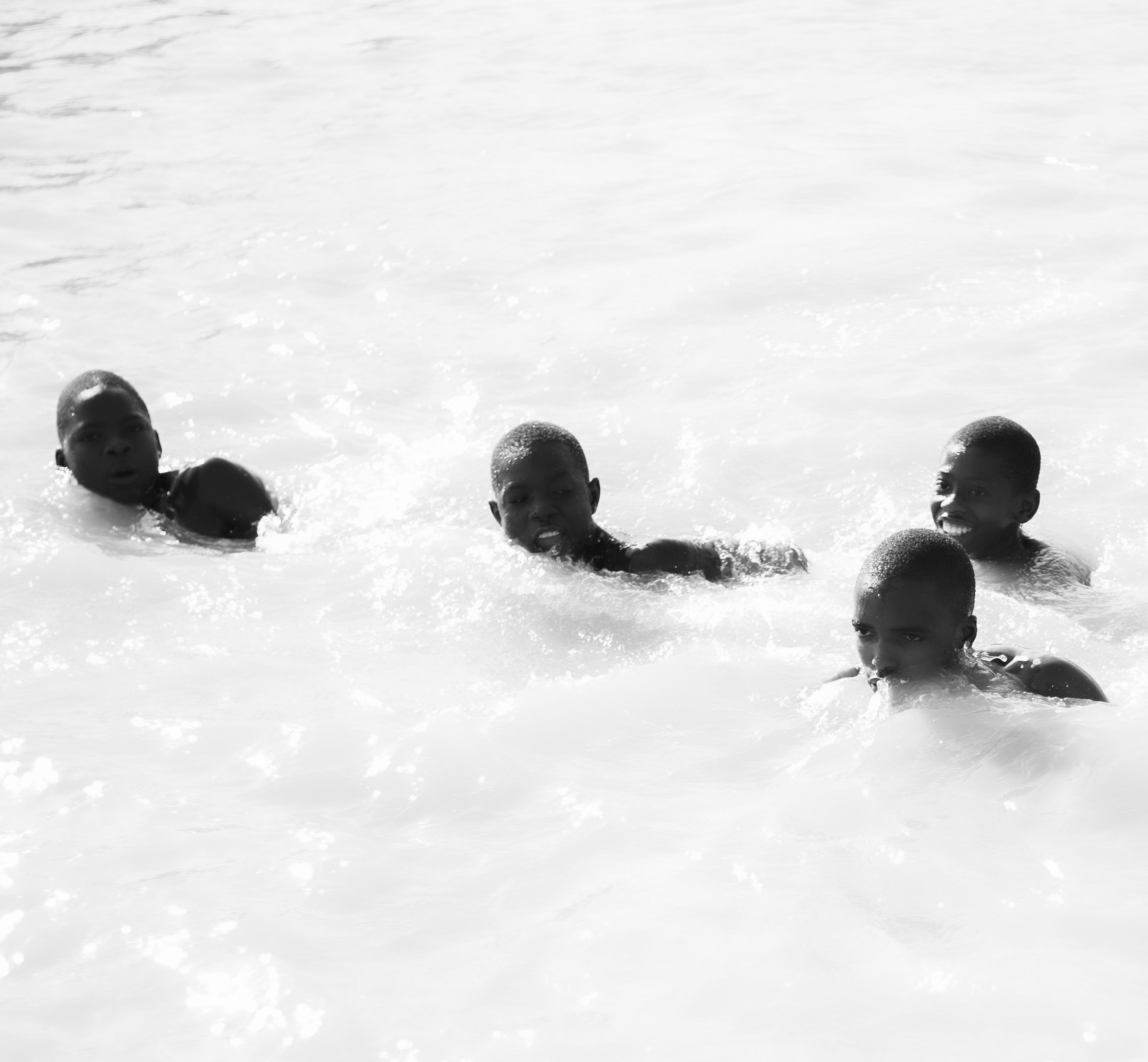 Joyful Boys Swimming in Sunlit Waters · Free Stock Photo