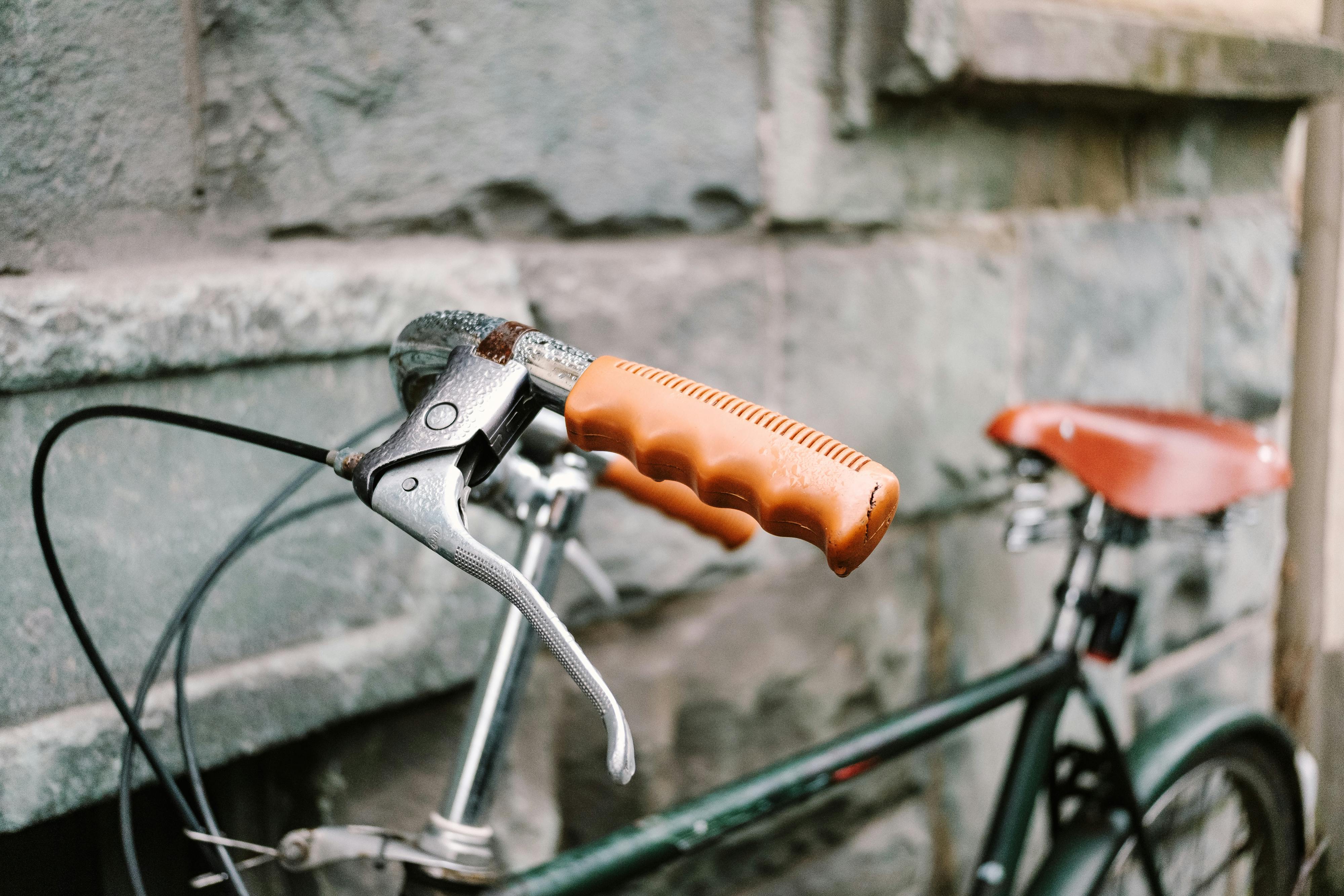 Vintage Bicycle Handlebar Detail with Stone Wall · Free Stock Photo