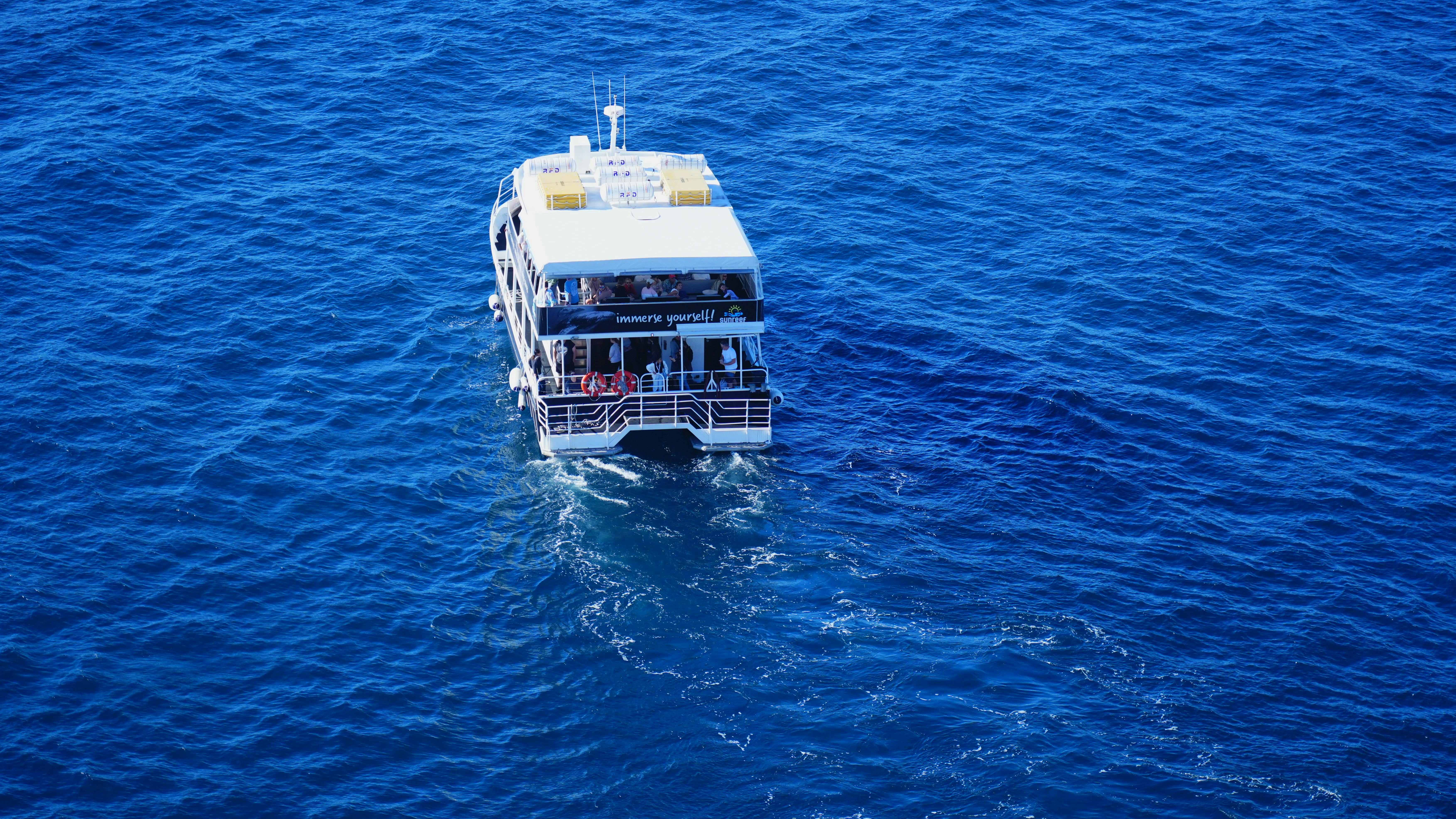 Aerial View of Boat Navigating Blue Ocean Waters · Free Stock Photo