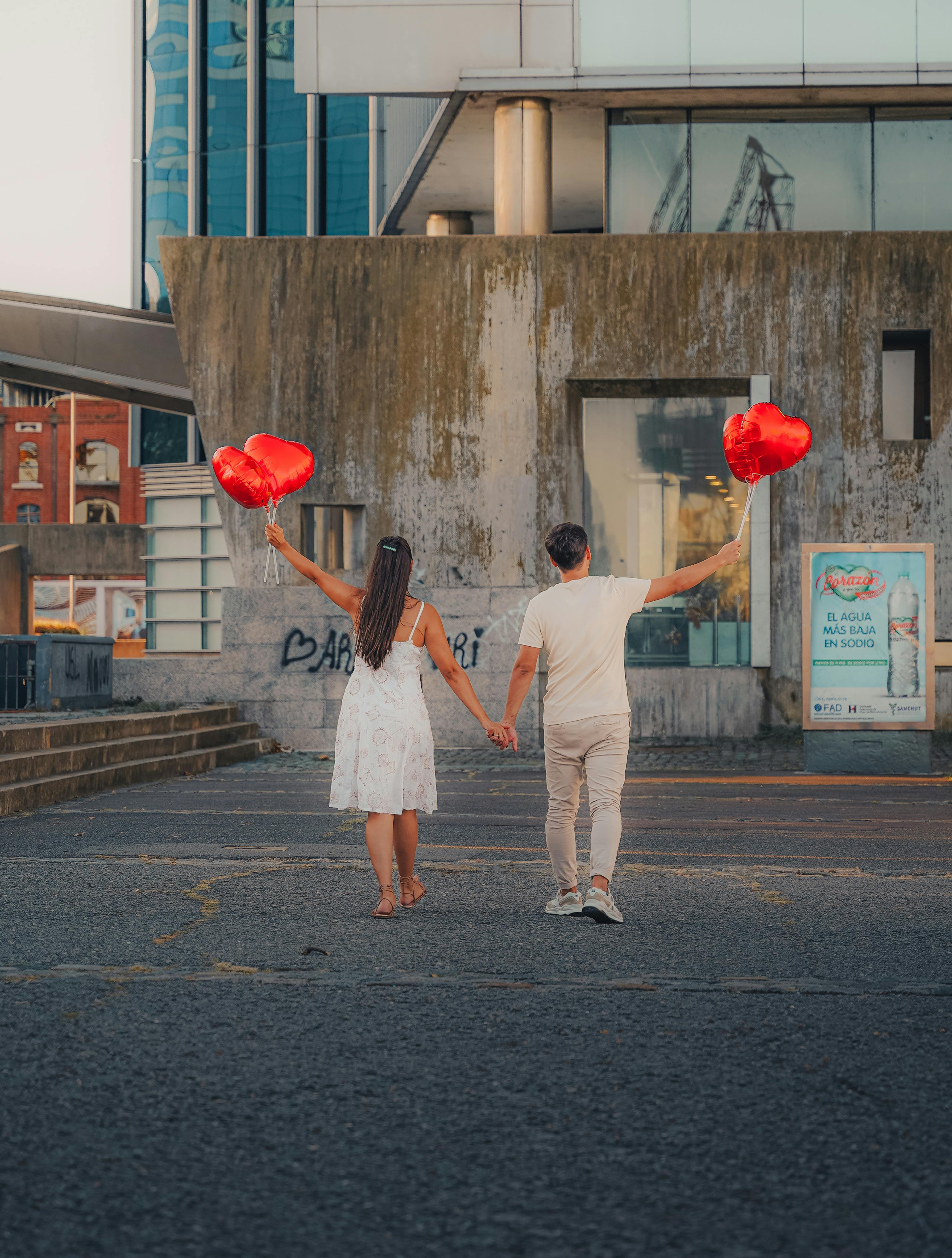 Romantic Couple Walking with Heart Balloons · Free Stock Photo