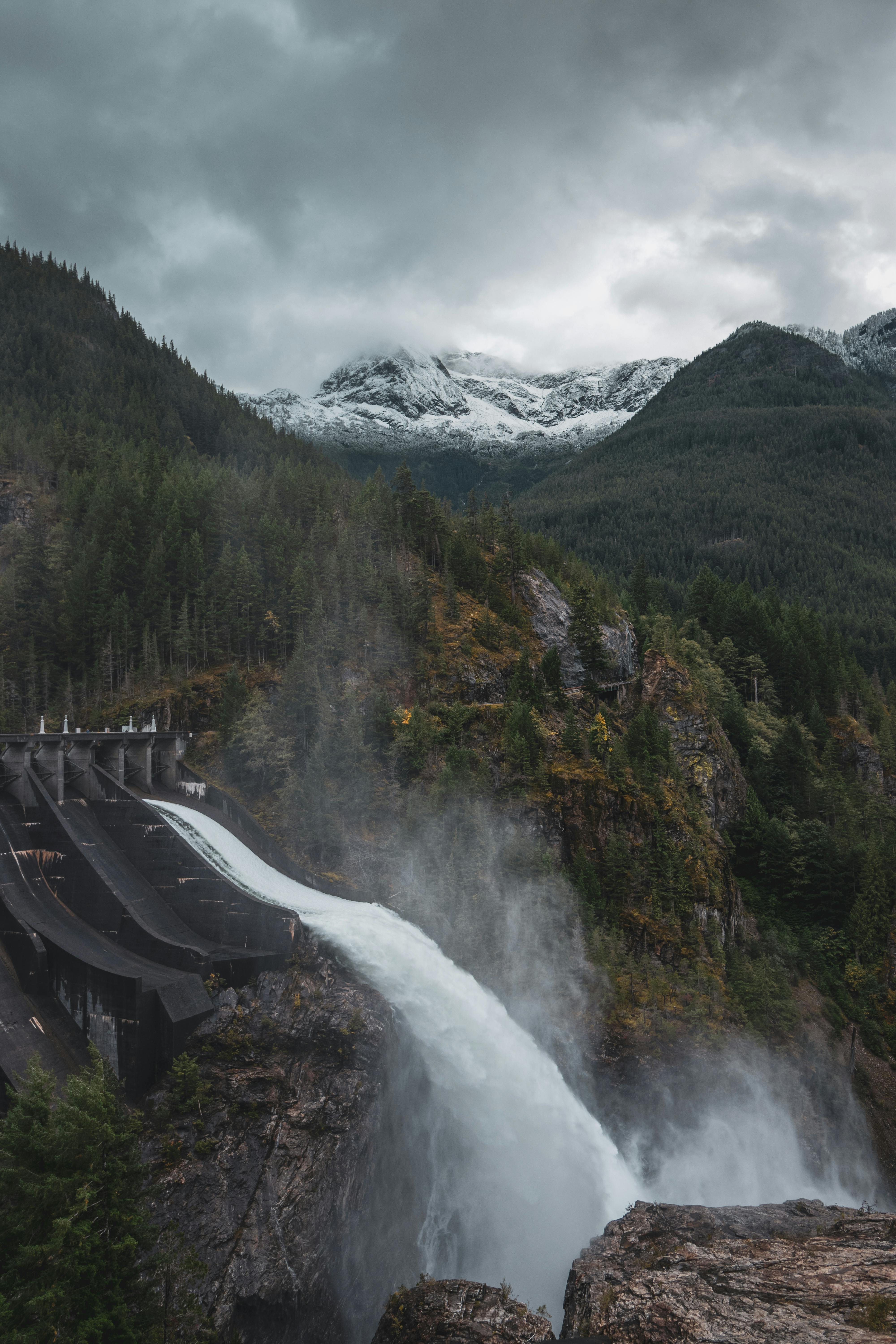 Majestic Mountain Dam with Overflowing Spillway · Free Stock Photo