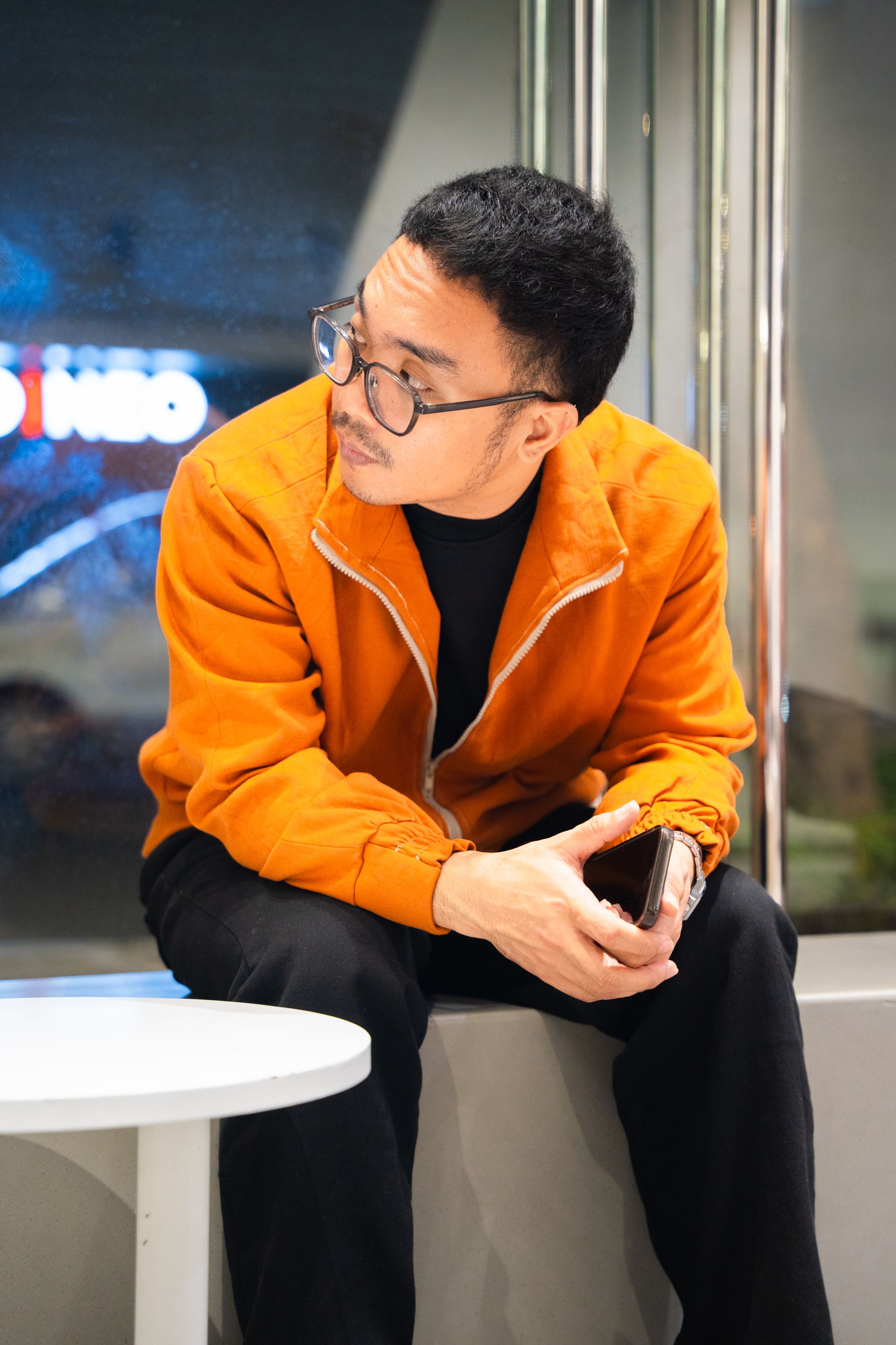 Man with Orange Jacket Holding Smartphone · Free Stock Photo
