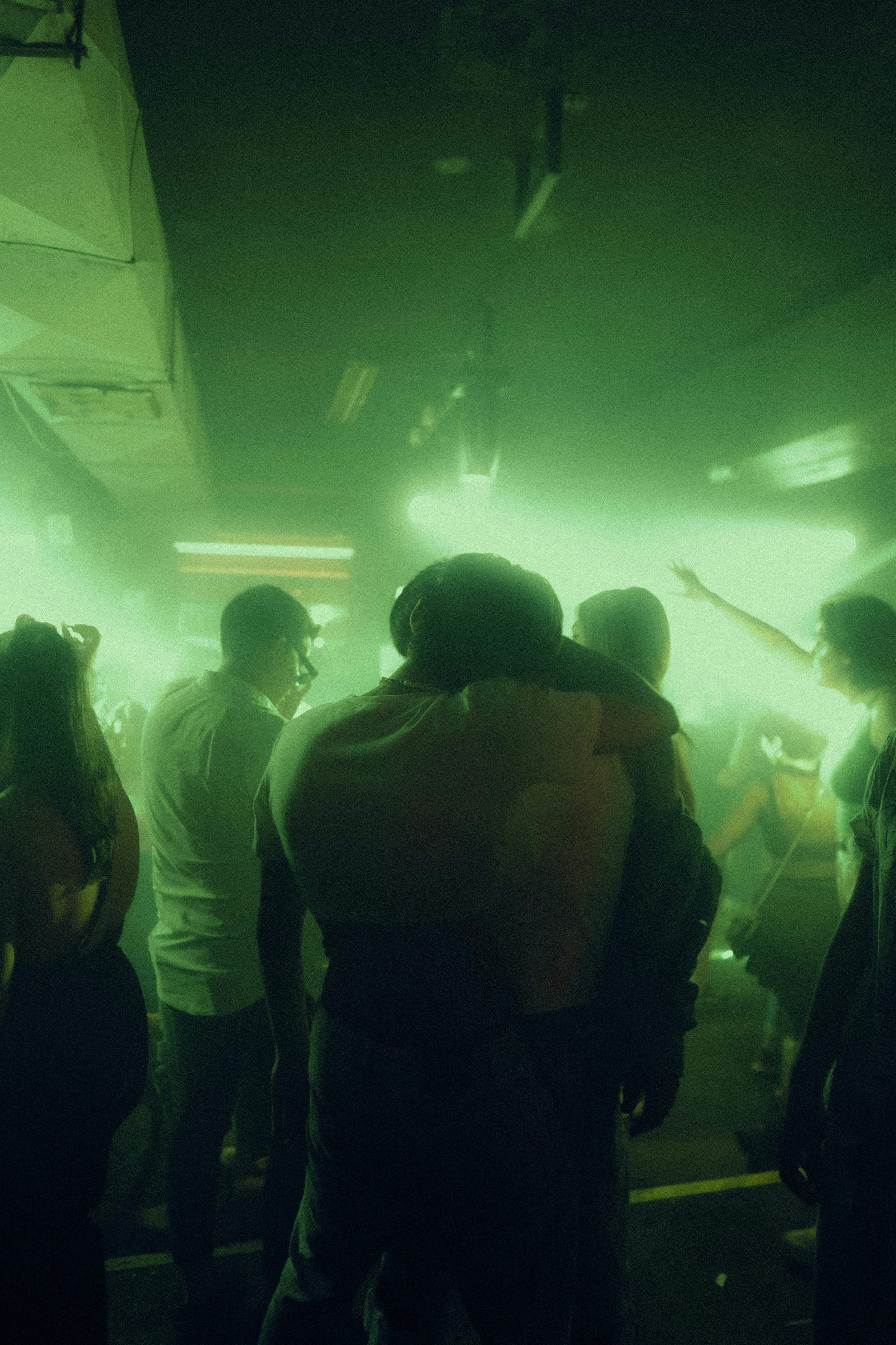 Couple Embracing in a Vibrant Club Atmosphere · Free Stock Photo